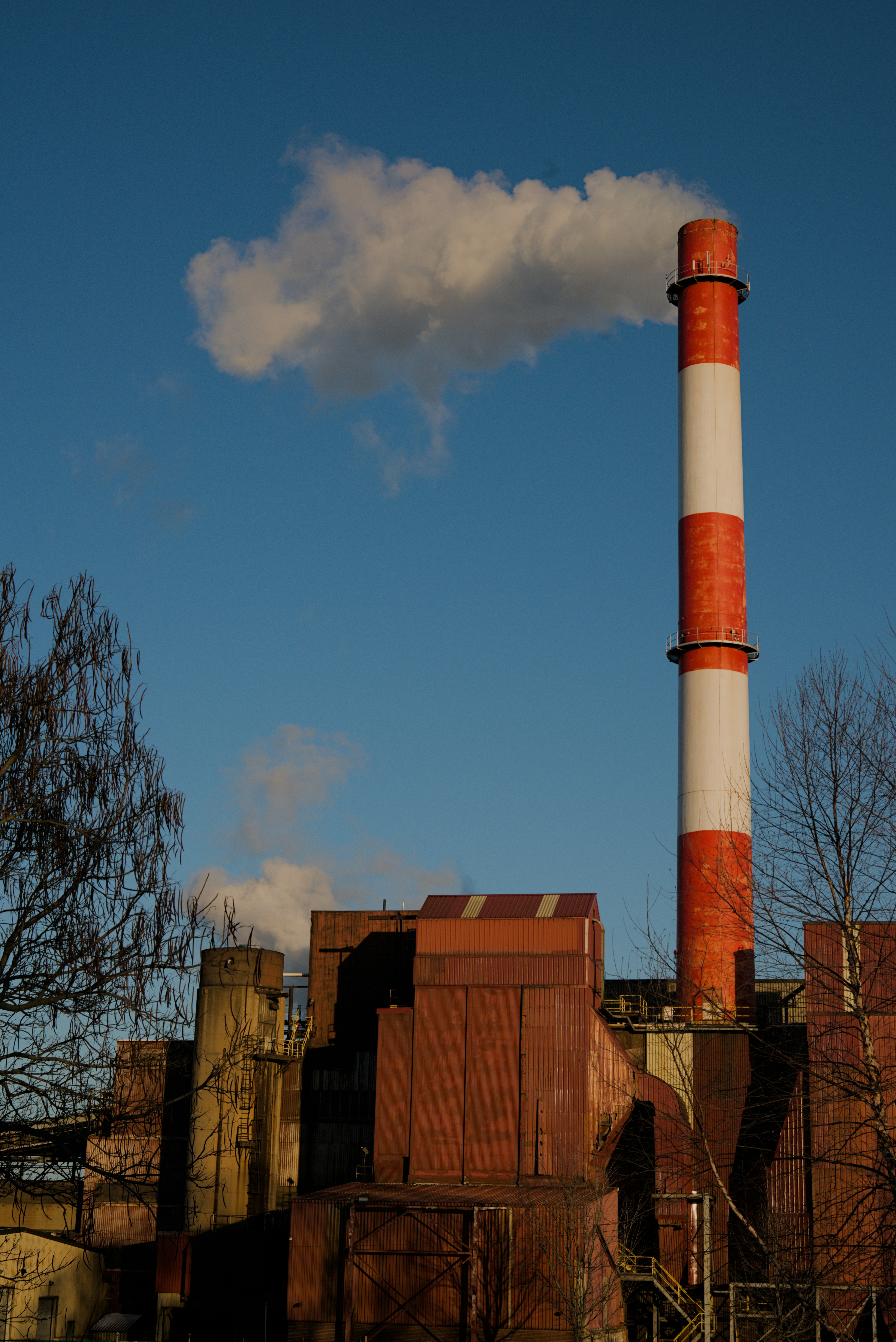 Industrial Smoke and Sunset: Chimney Piercing the Blue