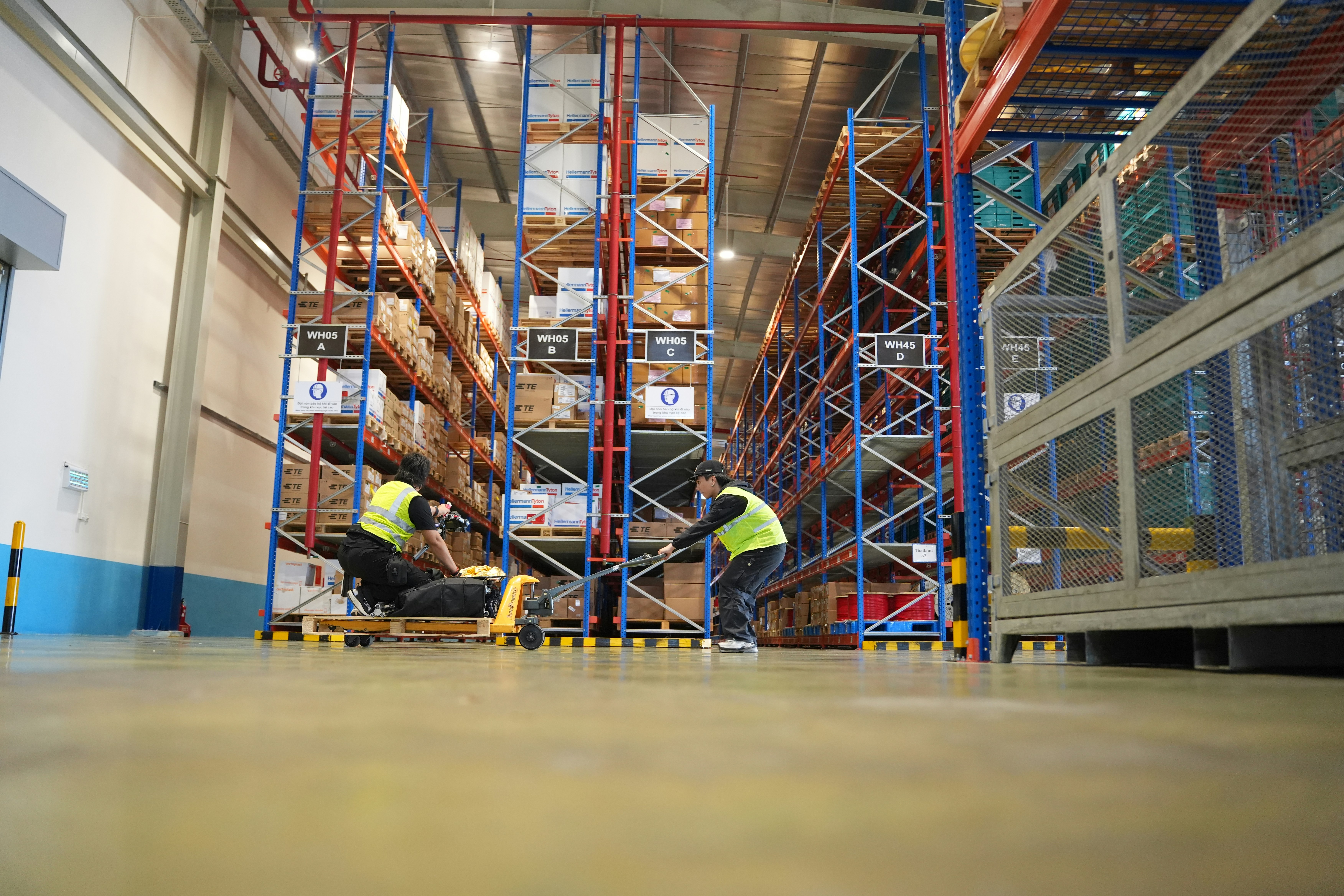 Workers organizing shelves in a large warehouse.