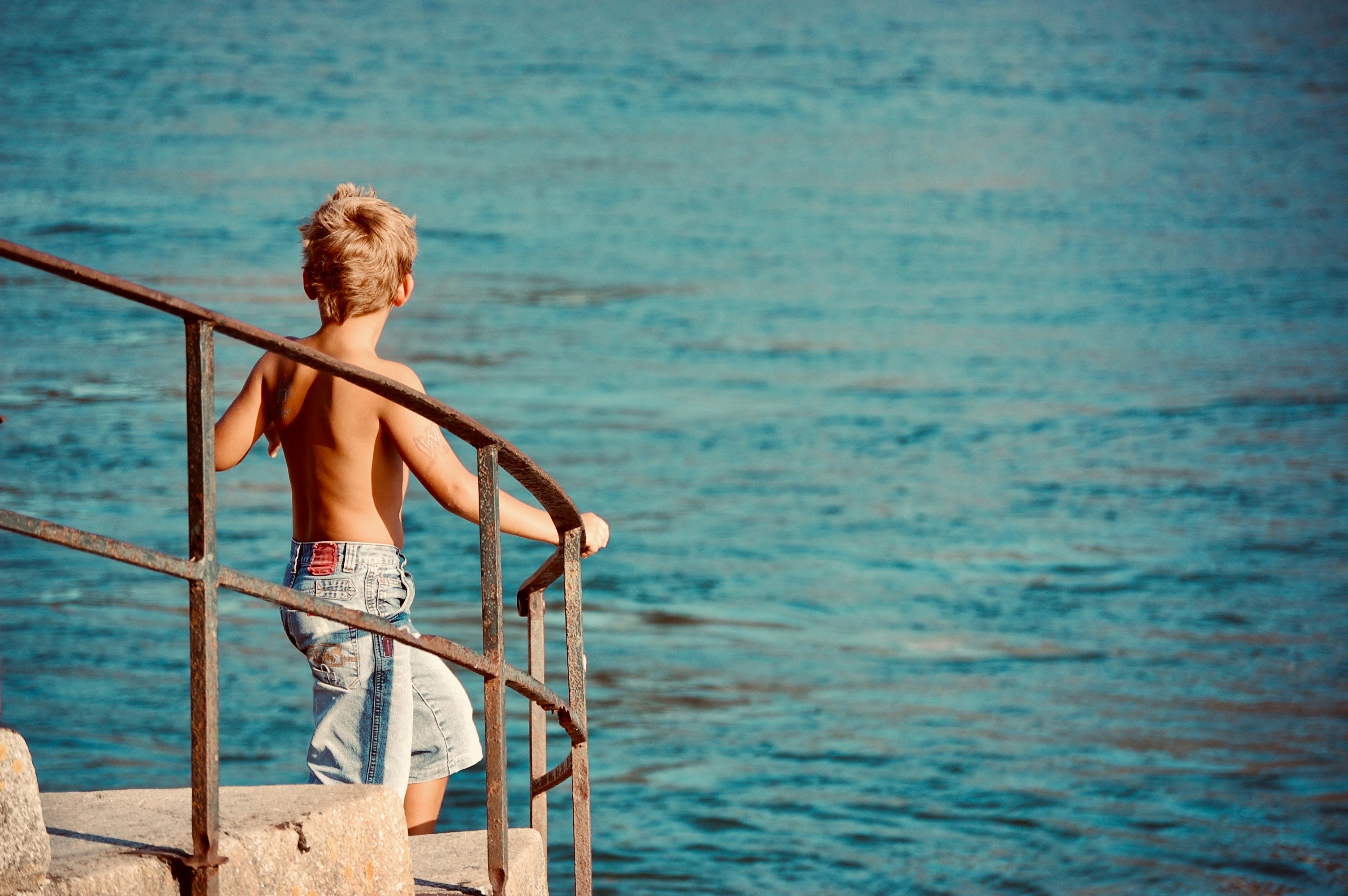 Youth on the Railing: A Quiet Gaze Toward the Sea