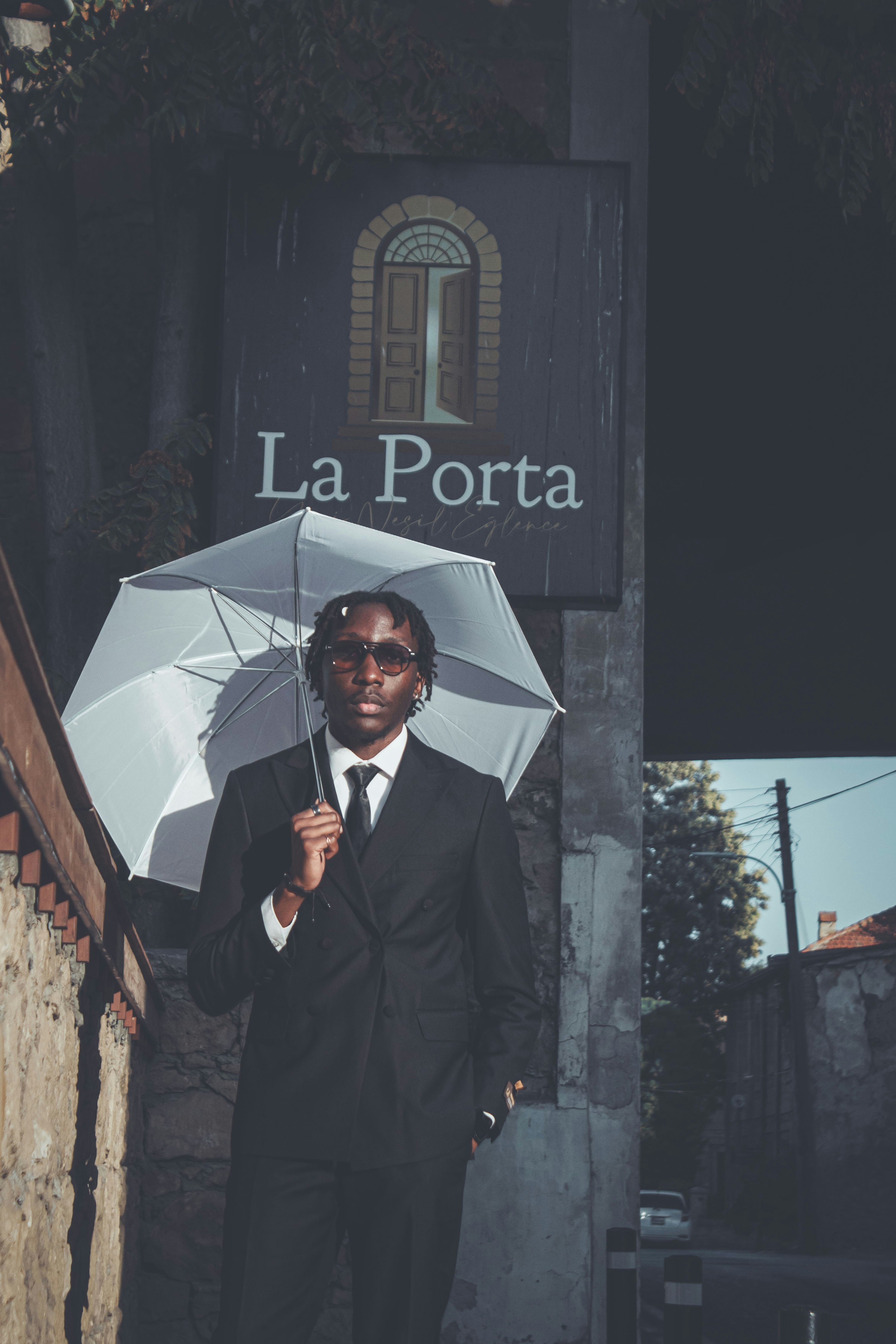 Umbrella in the Spotlight: A Dapper Presence Beneath La Porta