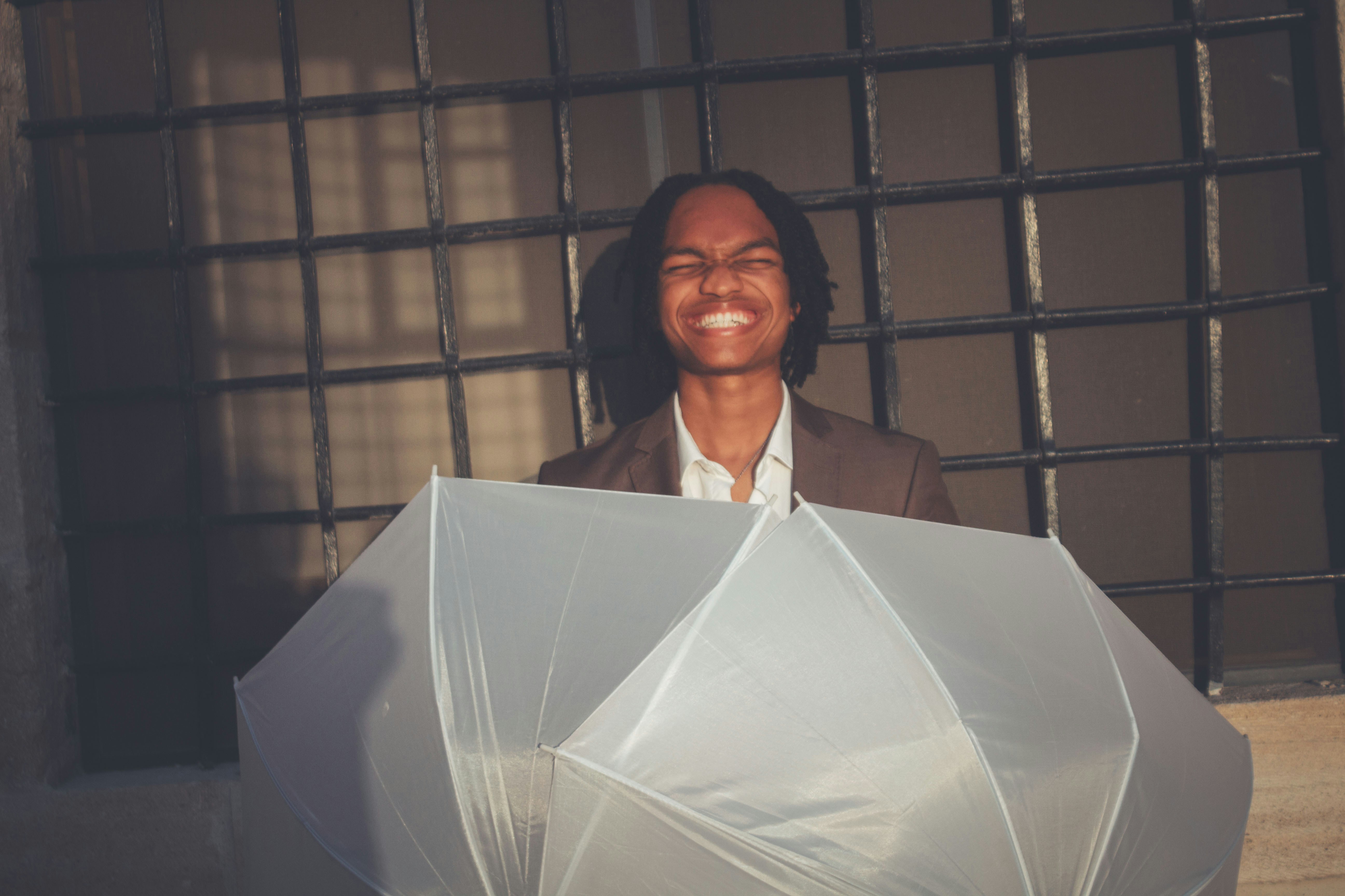 Smiles Under Shine: A Portrait Behind a Modern Umbrella