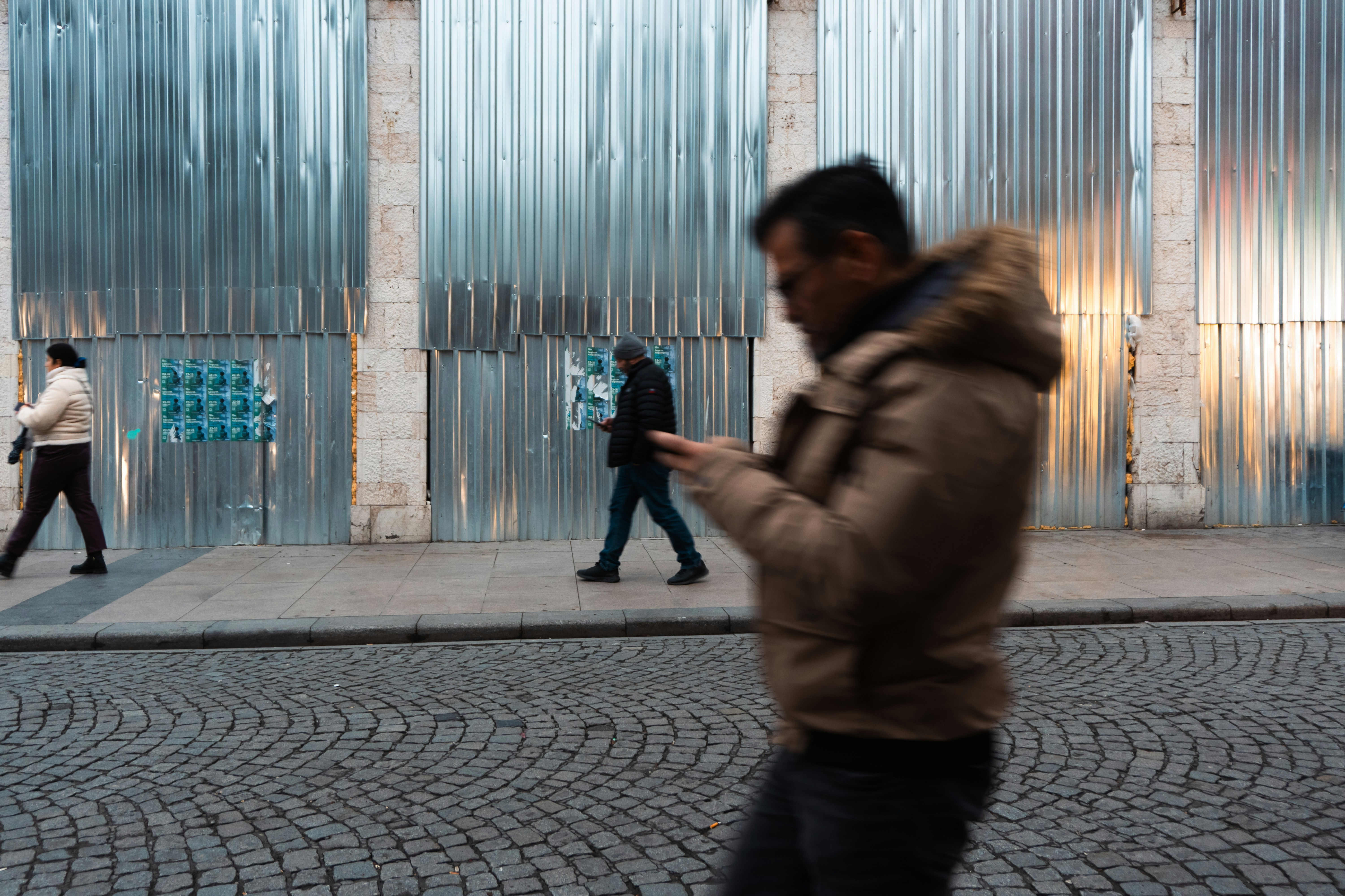 Blurred Pedestrian in Front of Corrugated Metal Facade
