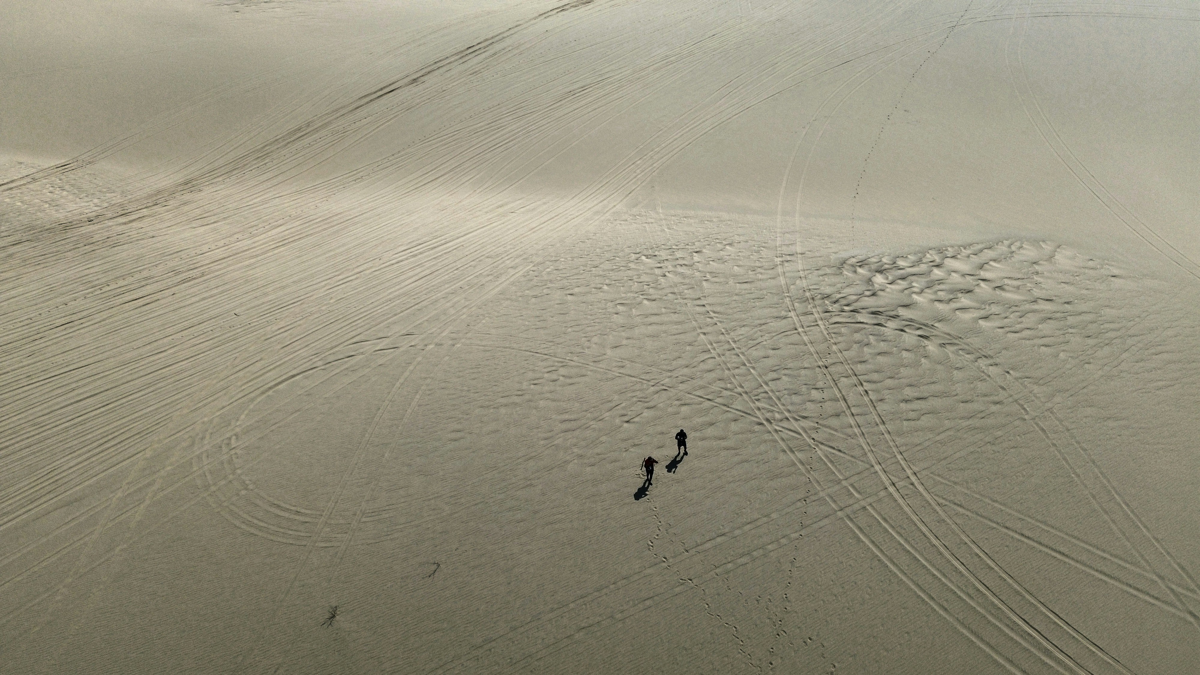 Sandship Trails: Trio Walking Across Dune Art
