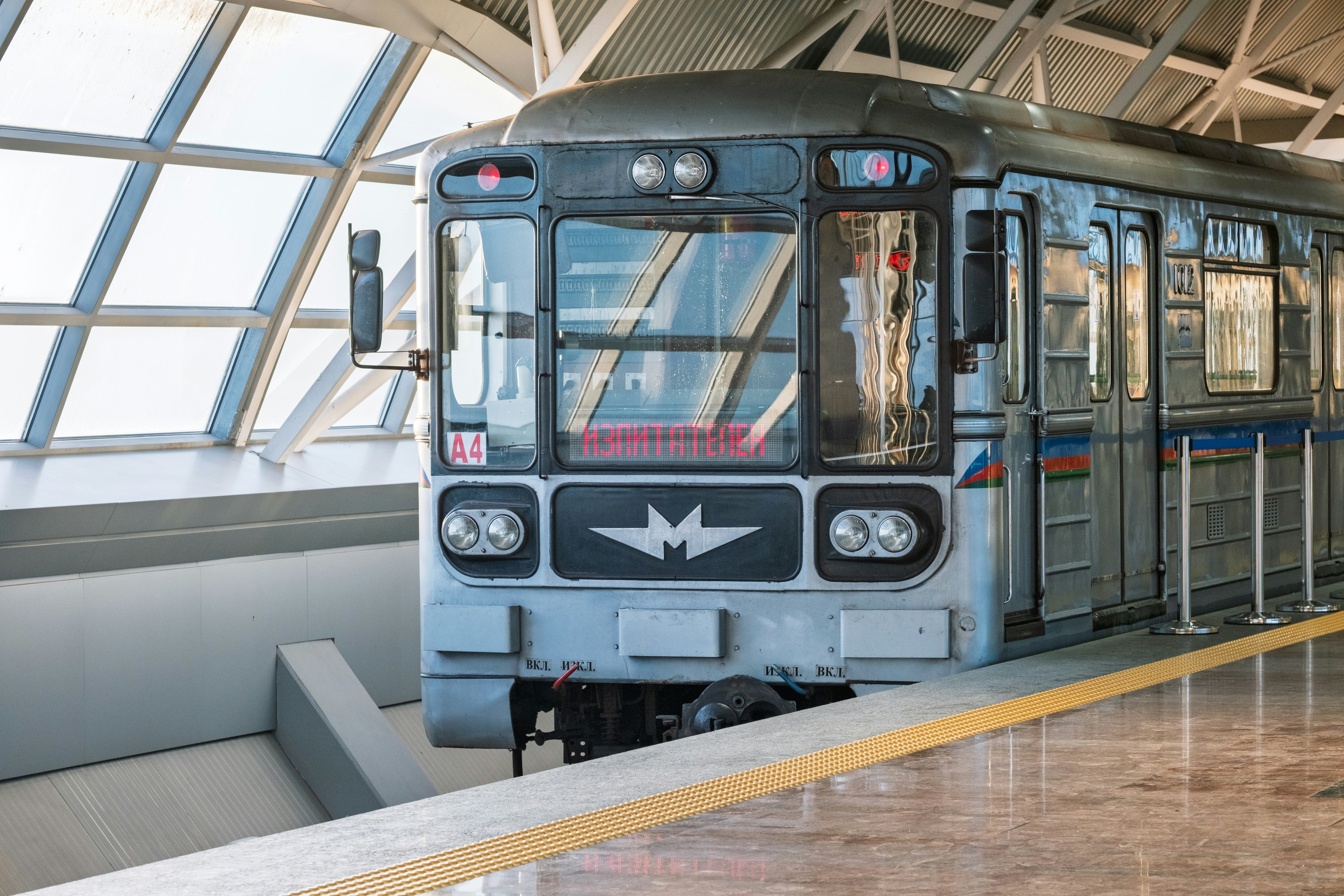 Front Illumination: A Blue Metro Train at a Sunlit Station