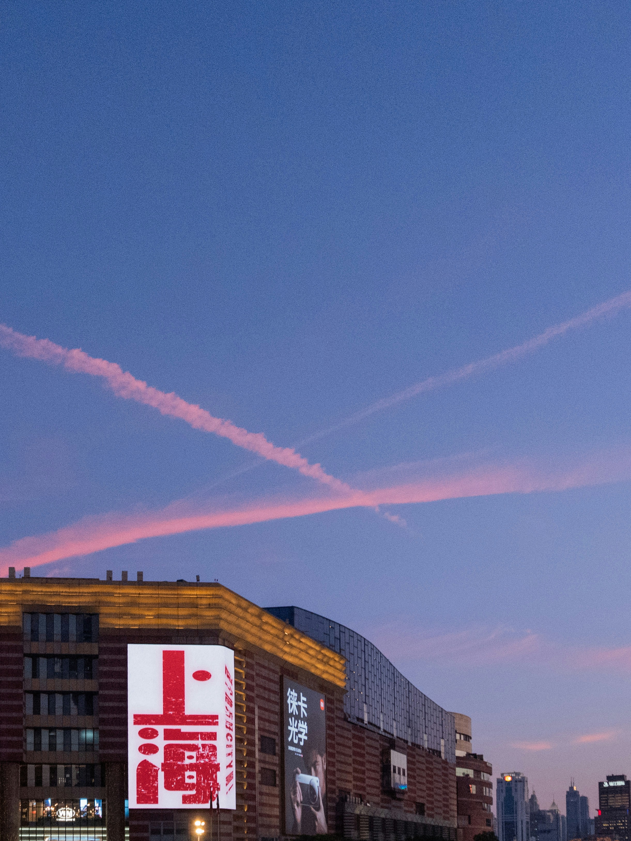 Building with glowing sign against pink sky