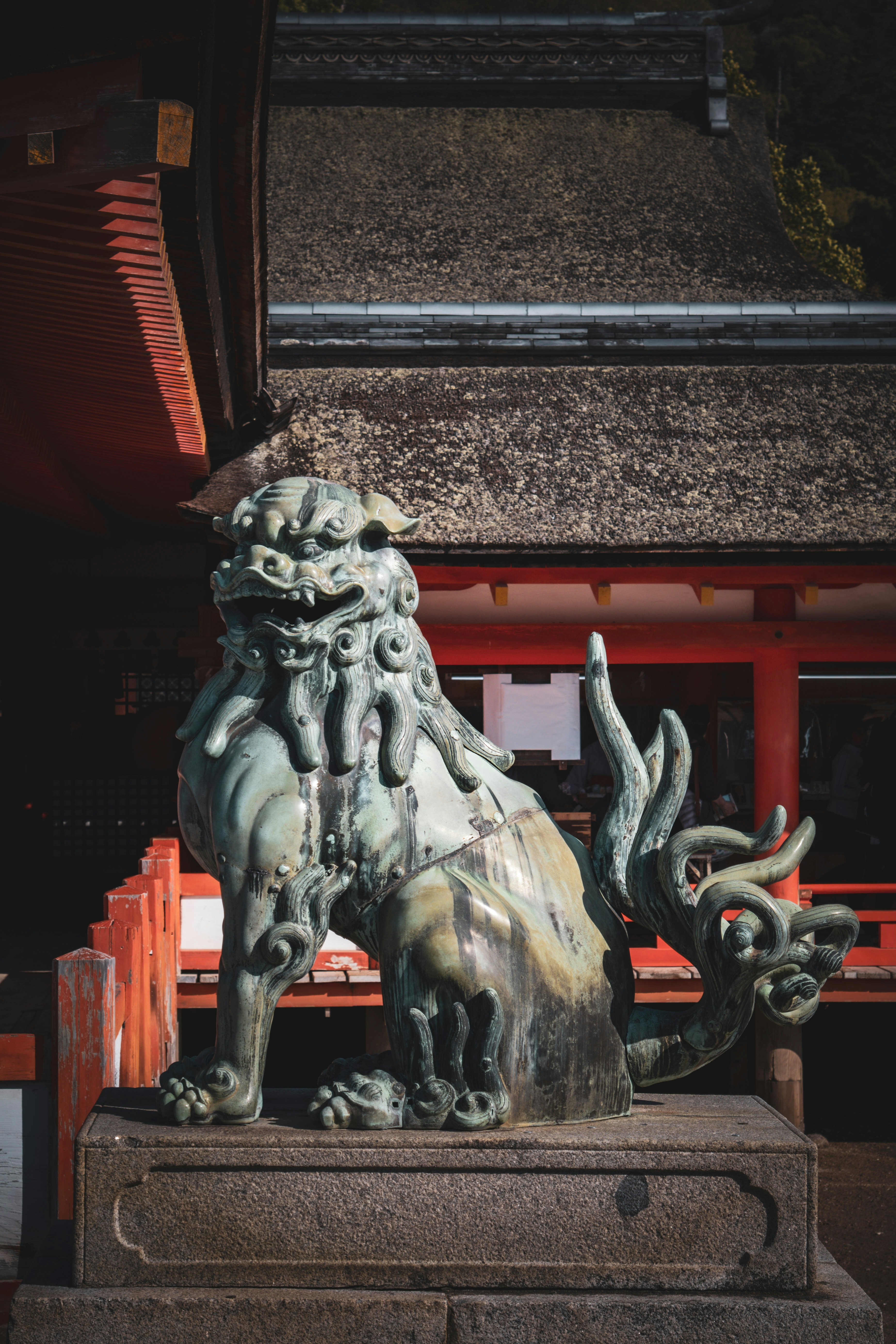 Bronze Guardian of the Temple: A Regal Lion Statue Against Red Geedroof