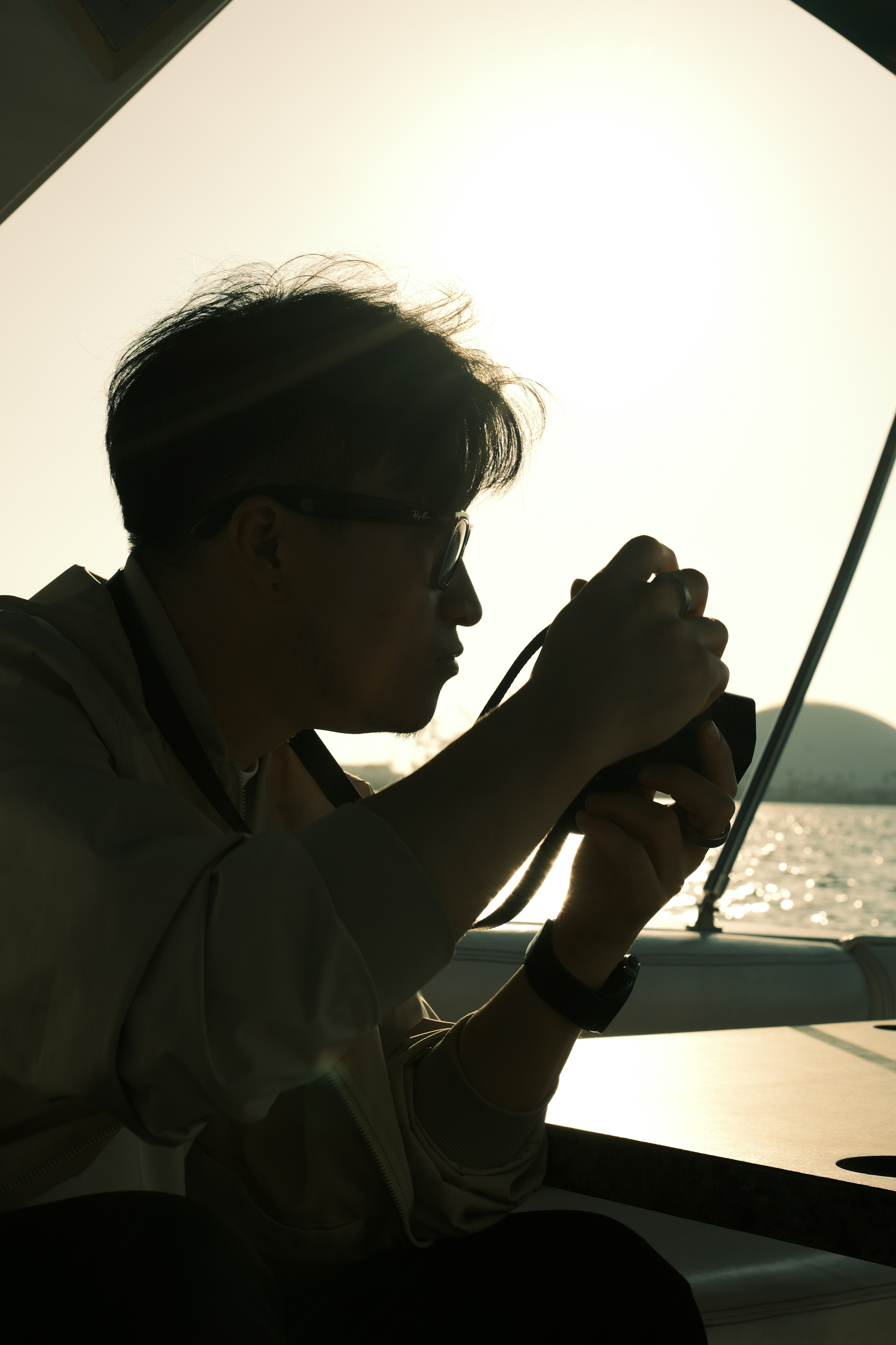 Silhouette of a Photographer on a Sunlit Deck