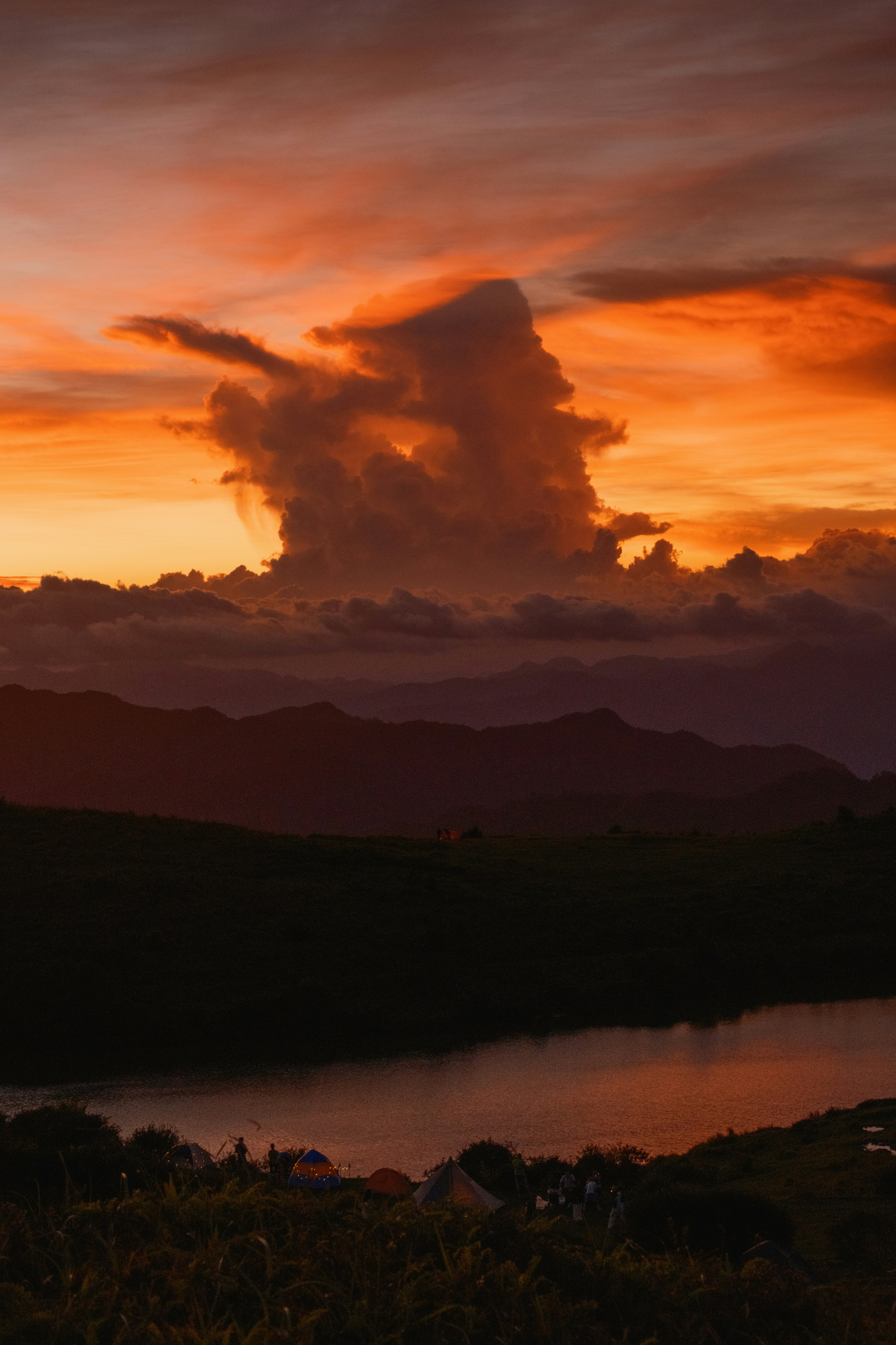 Crimson Cloudscape Over Quiet Waters at Dusk