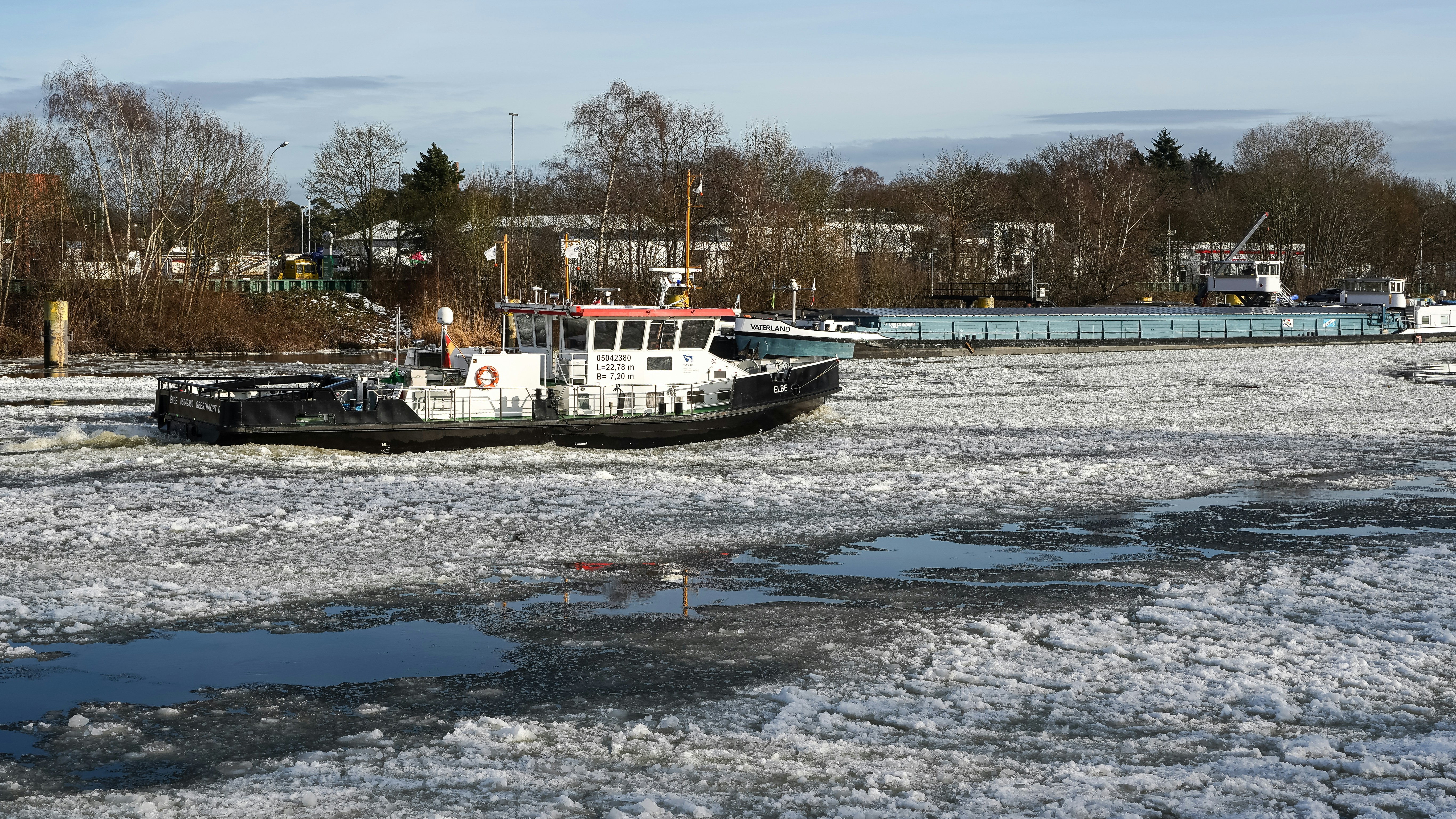 Icebound Tow: A Tidal Tug Navigates a Patchwork Frozen Harbor