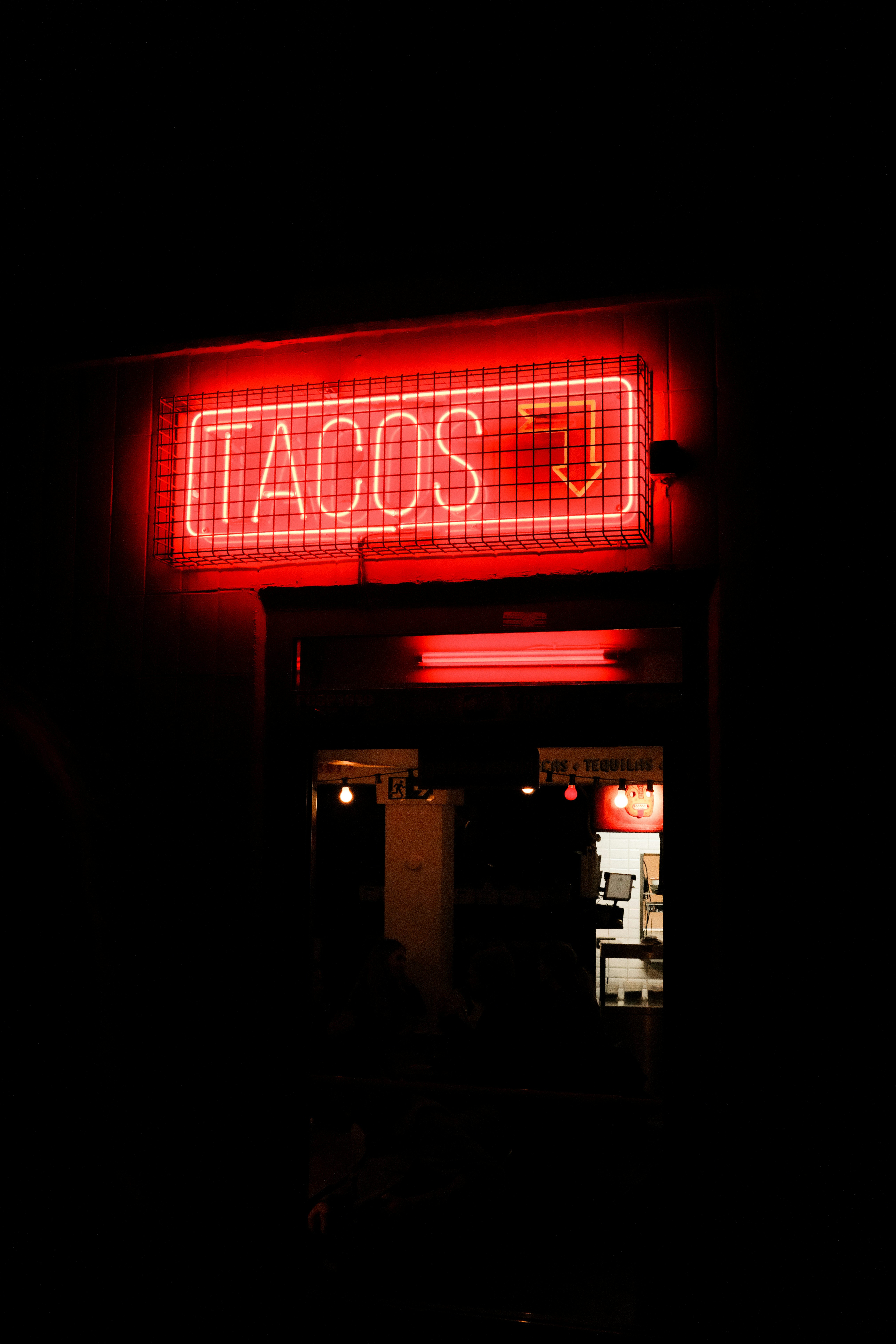 Red Neon Taco Sign Illuminates a Quiet Night Entrance