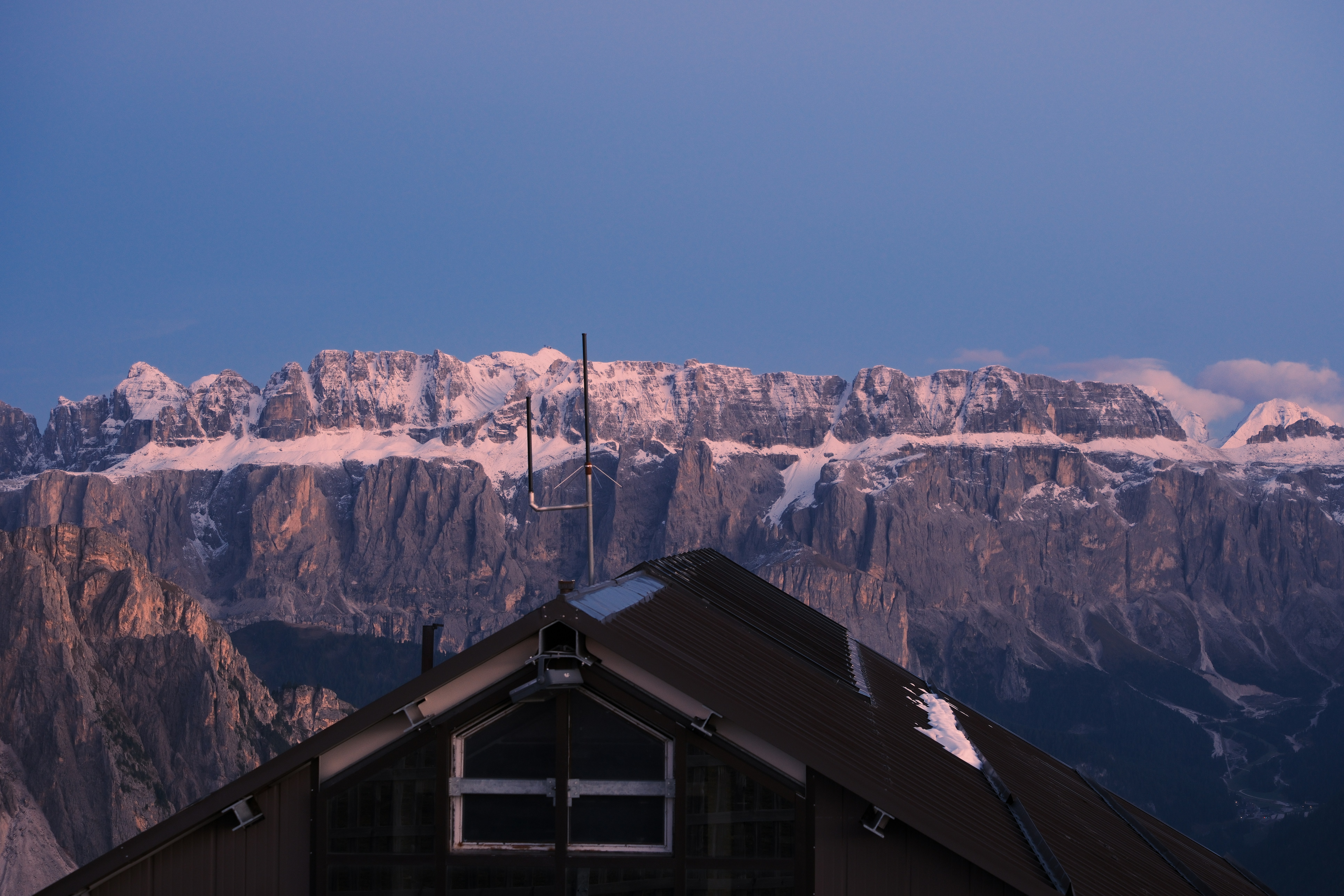 Snow-Capped Peaks Over a Stoic Rooftop
