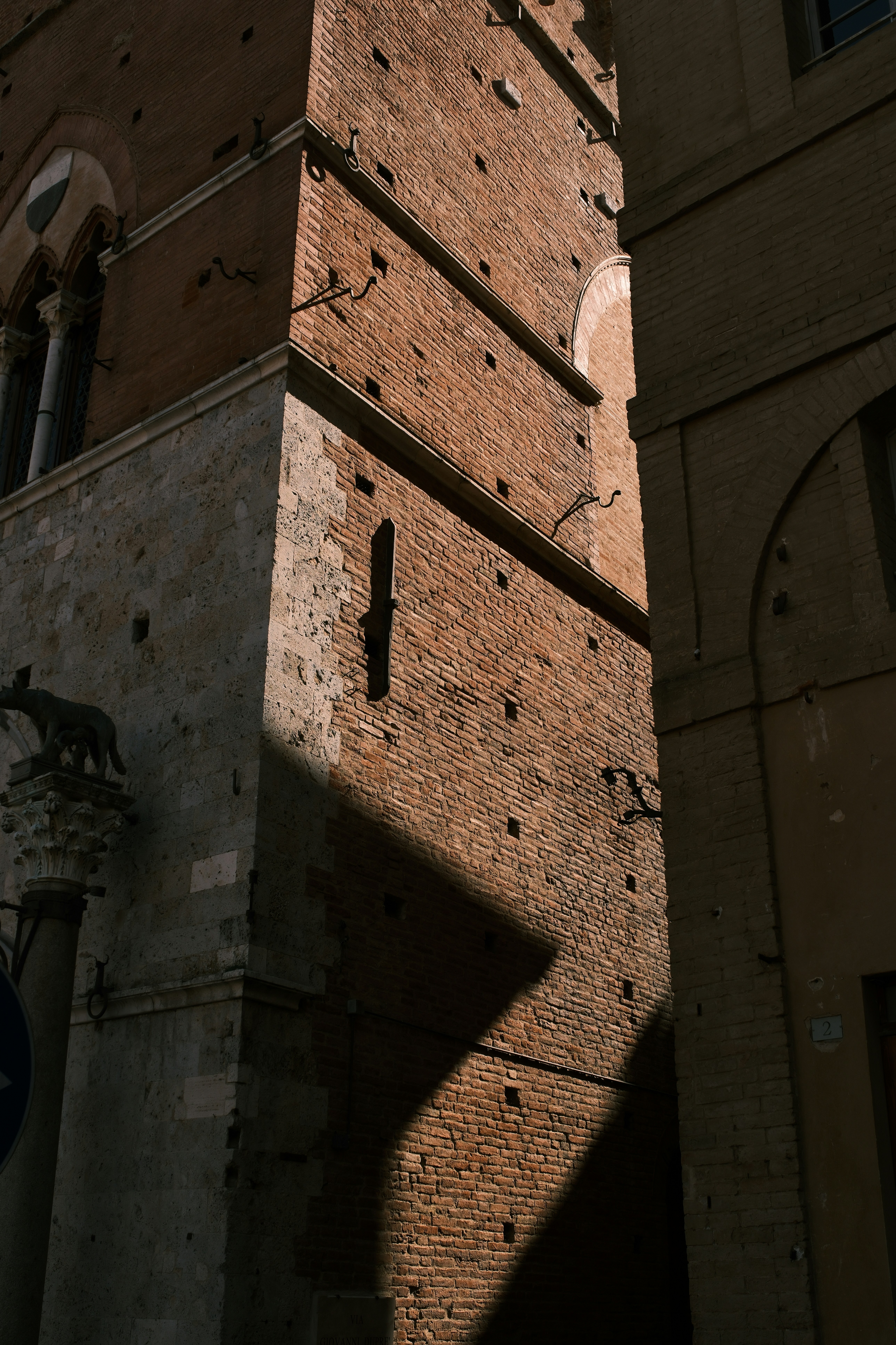 Shadowed Facade: A Brick Tower Partially in Sun