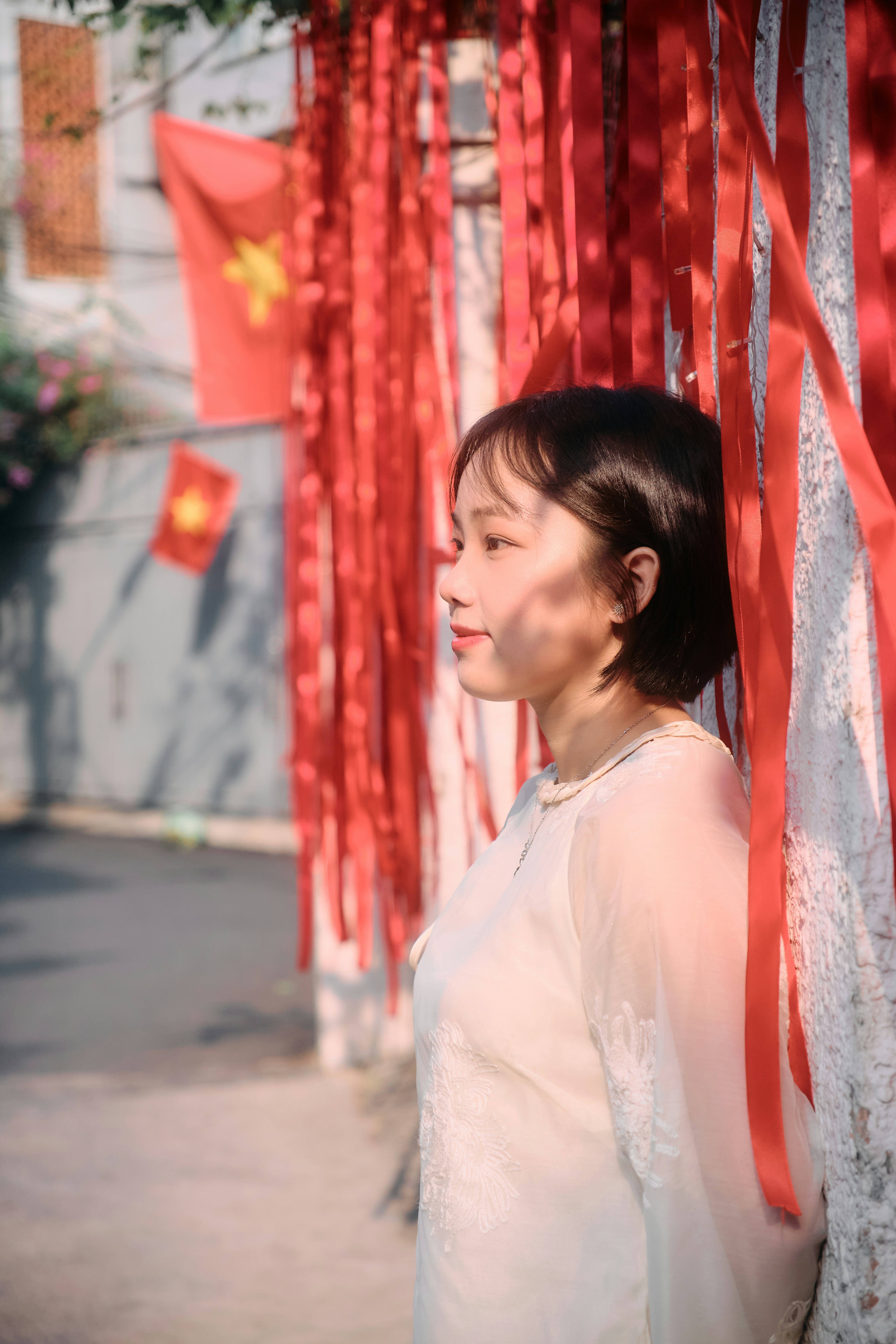 Red Ribbons and Quiet Light: A Portrait by the Wall of Flags