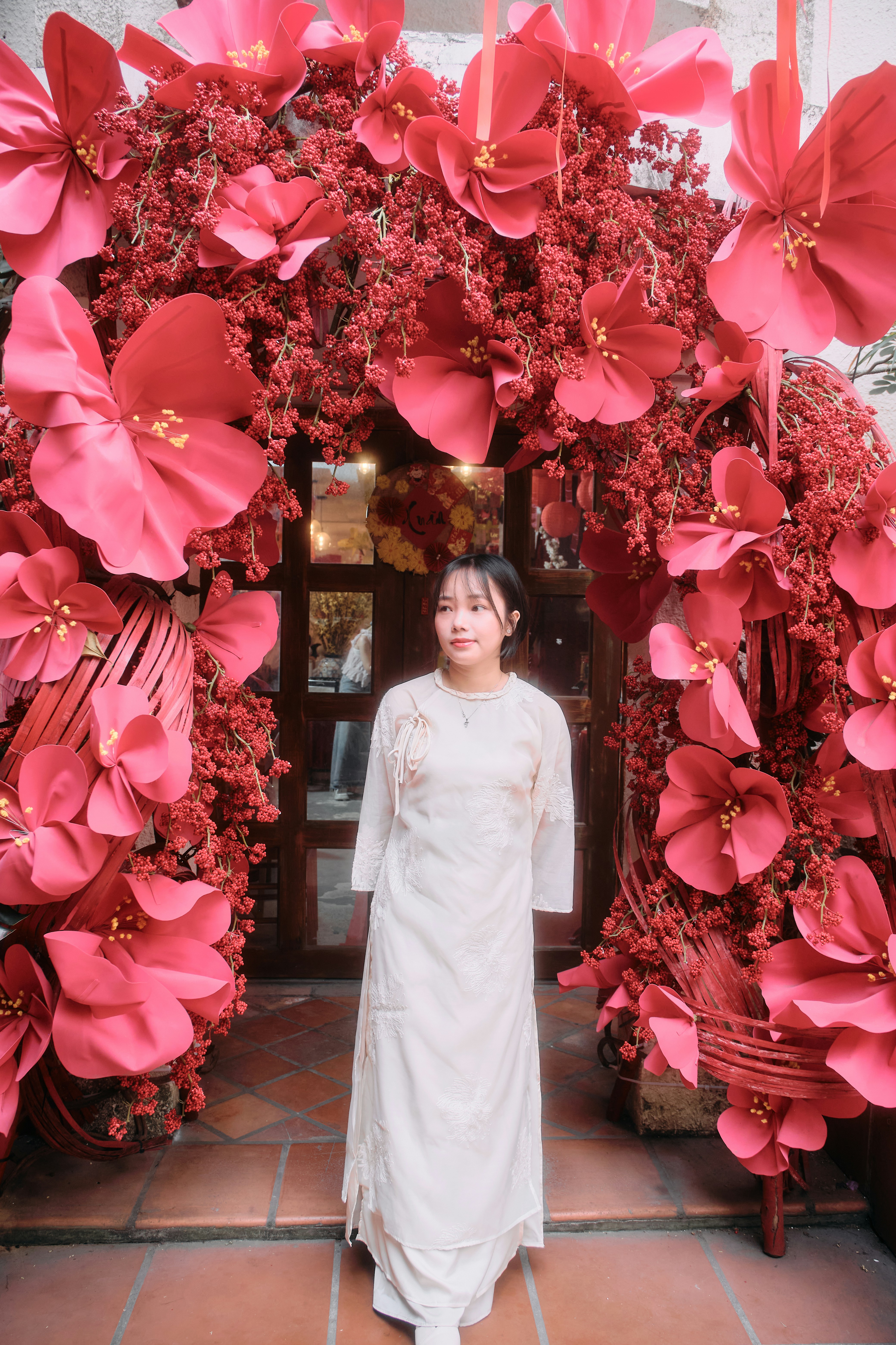 Floral Archway Frame: A Woman in Pale Dress Under a Sea of Pink Blossoms