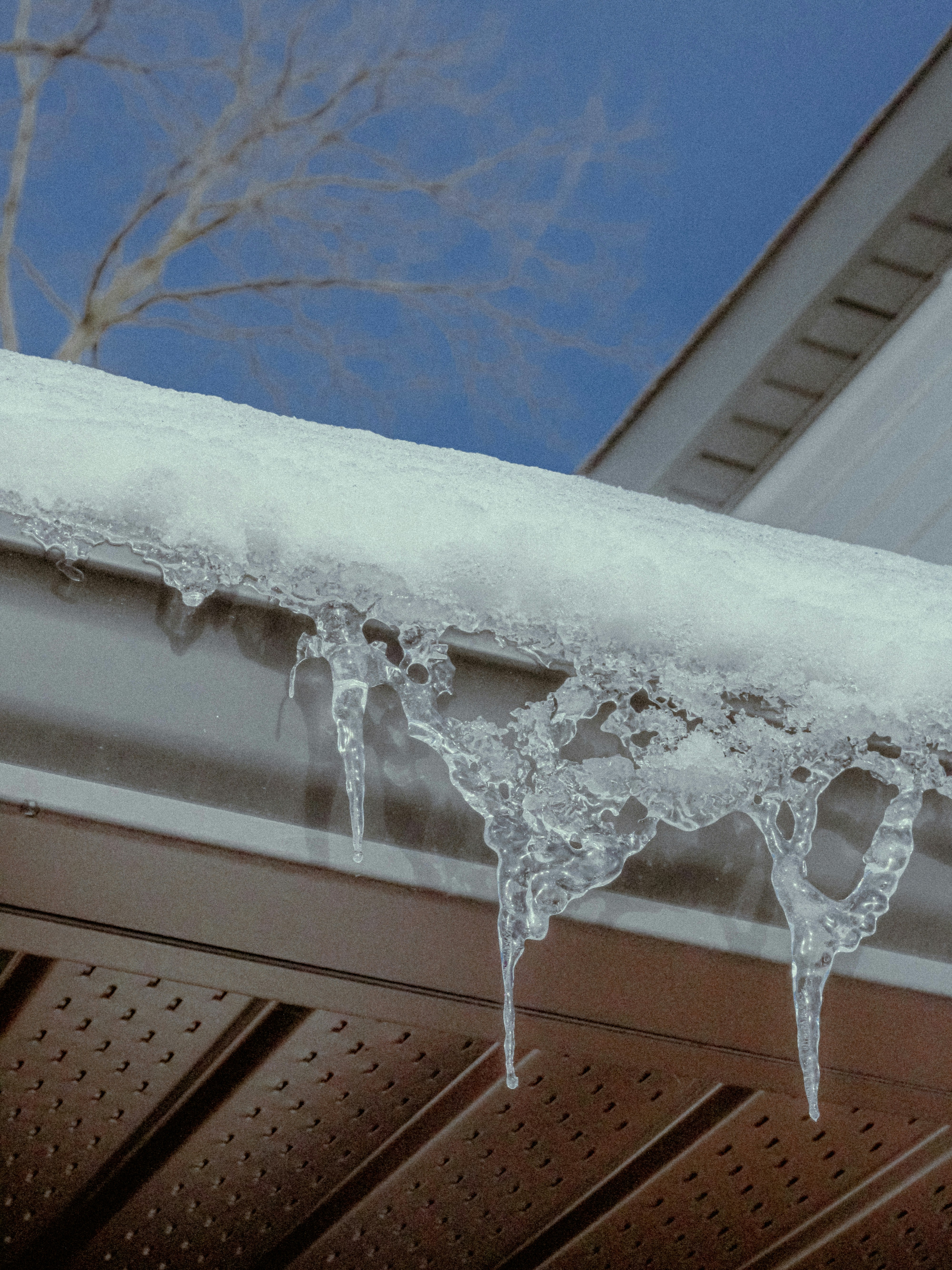 Icicle Sculpture Draped Across Snowy Roofline