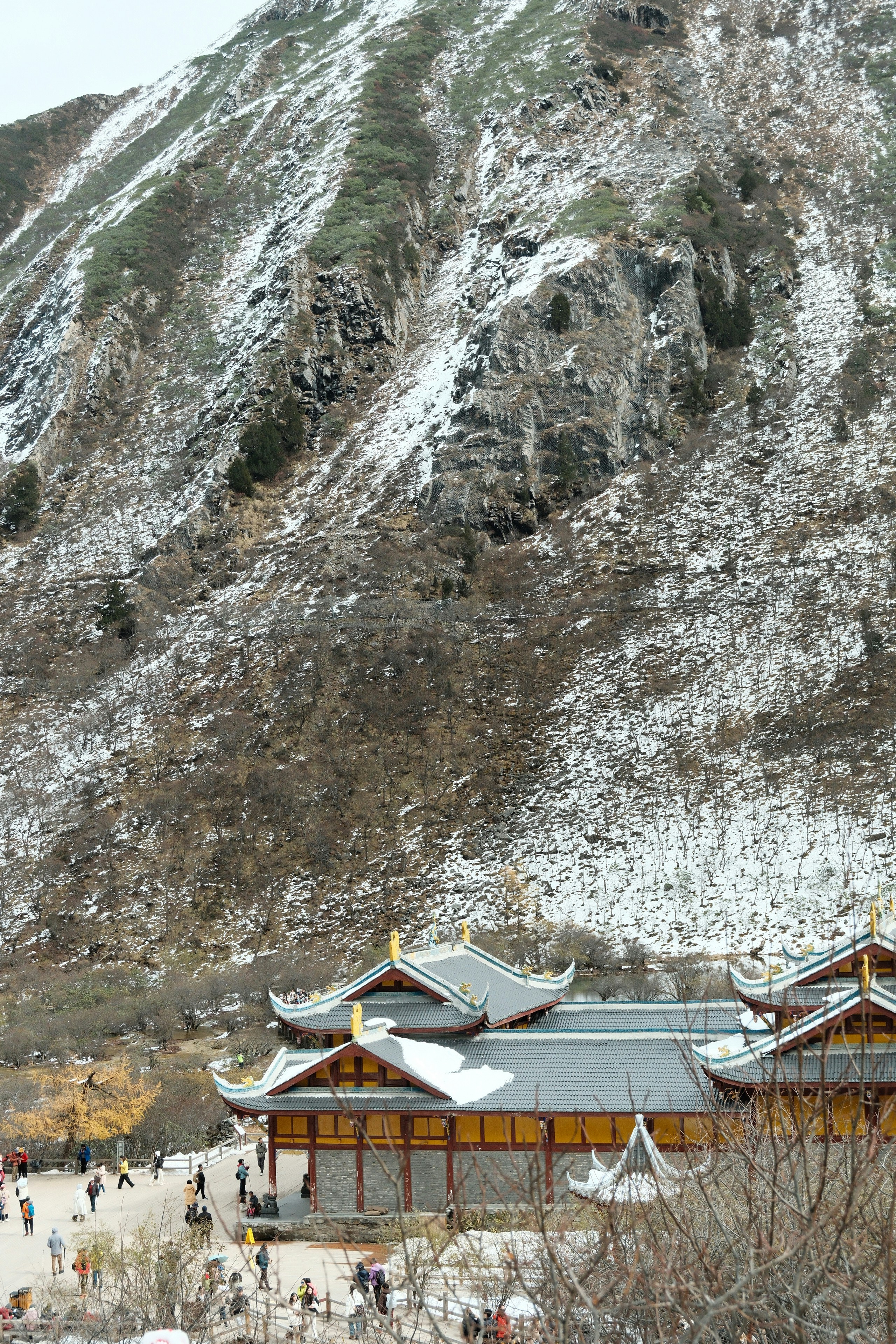 Temple Roofs at the Foot of a Snow-dusted Cliff