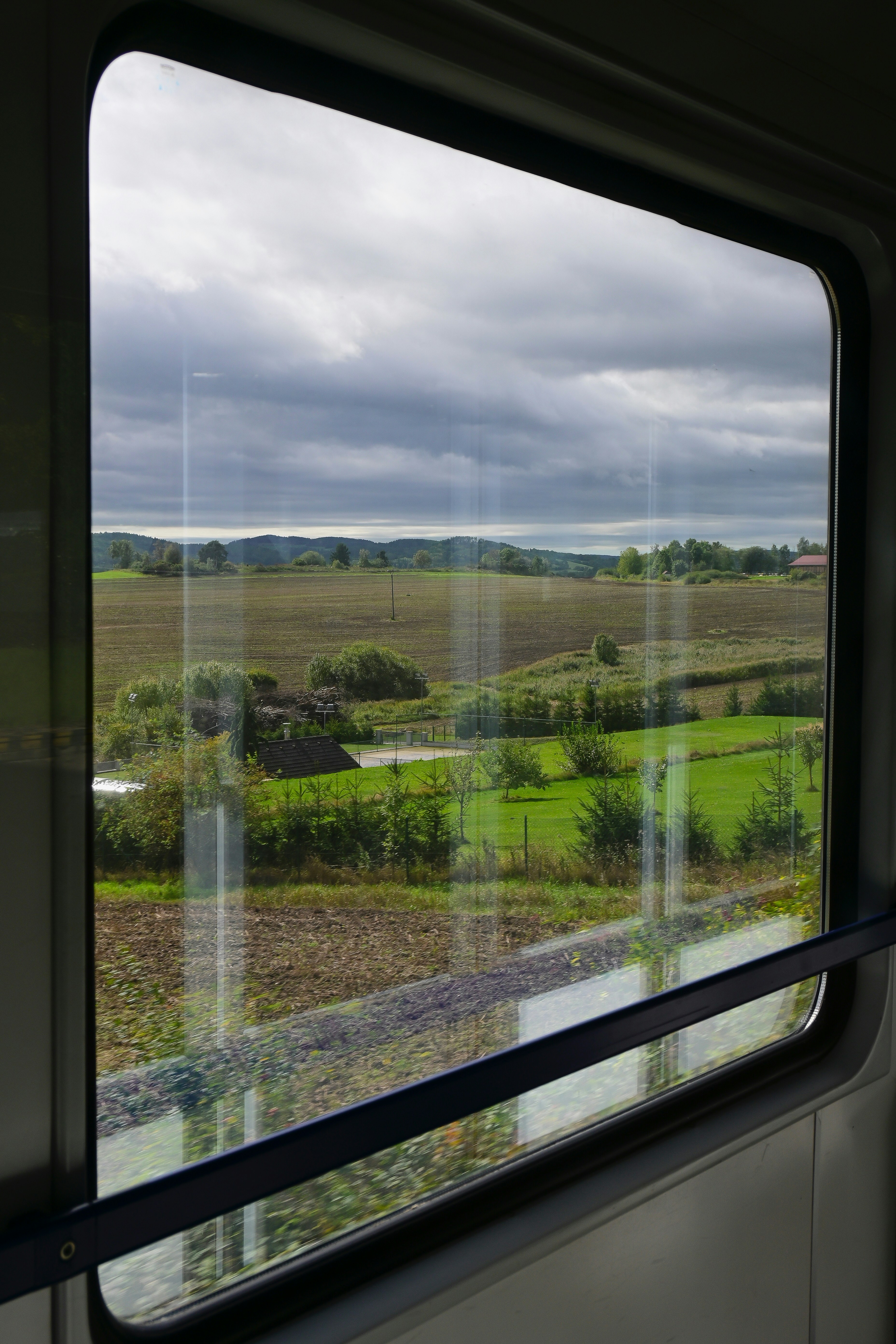 Windowed Pasture: Fields and Sky Through a Train Window