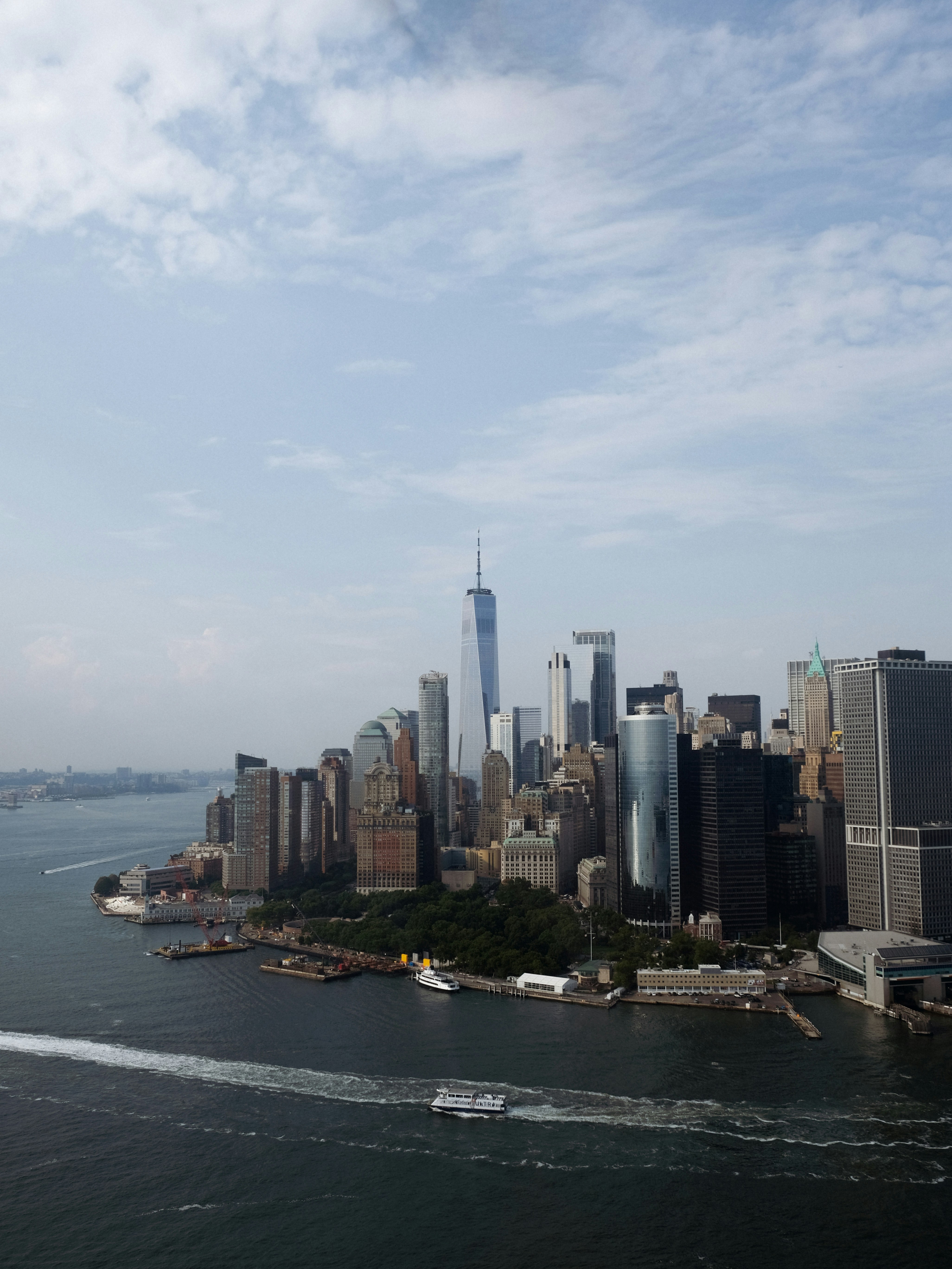 Skyscraper Skyline: Downtown Manhasset? (Note: NYC skyline with One World Trade Center rising above harbor) - Aerial cityscape over the water