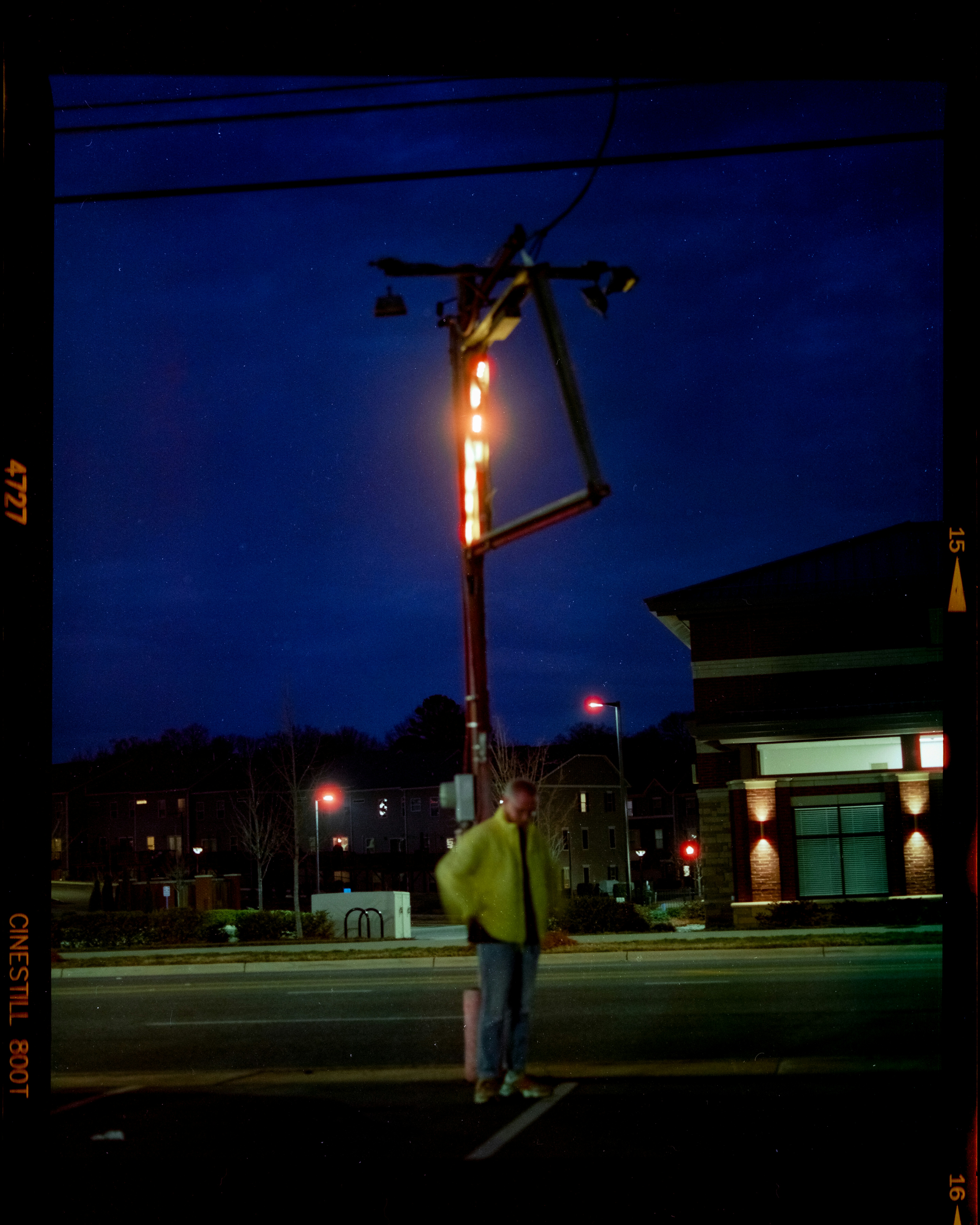 Night Portrait under a Vertical Lift at a Quiet Street Corner
