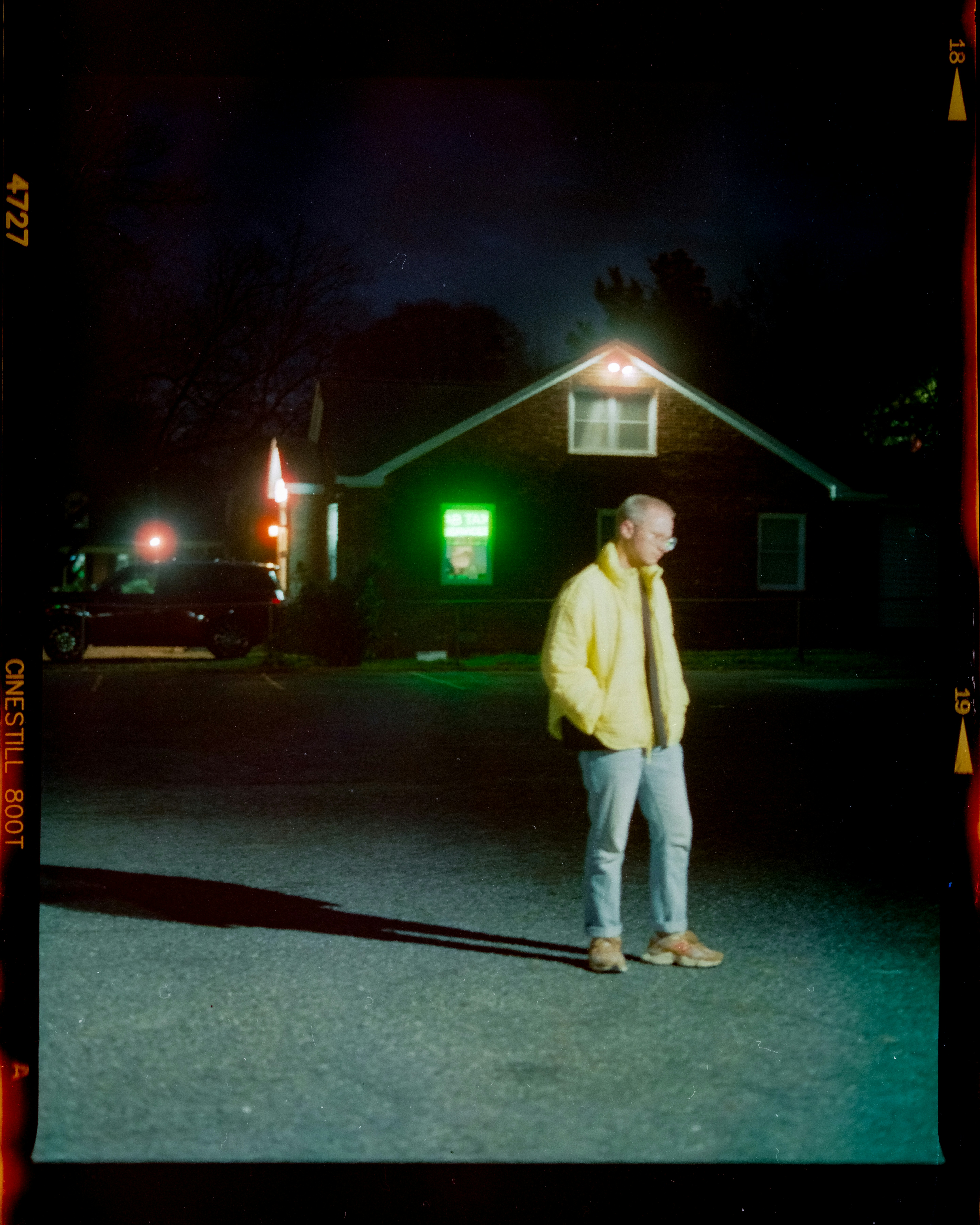 Neon Green Glimpse: A Lone Figure at a Nighttime Corner