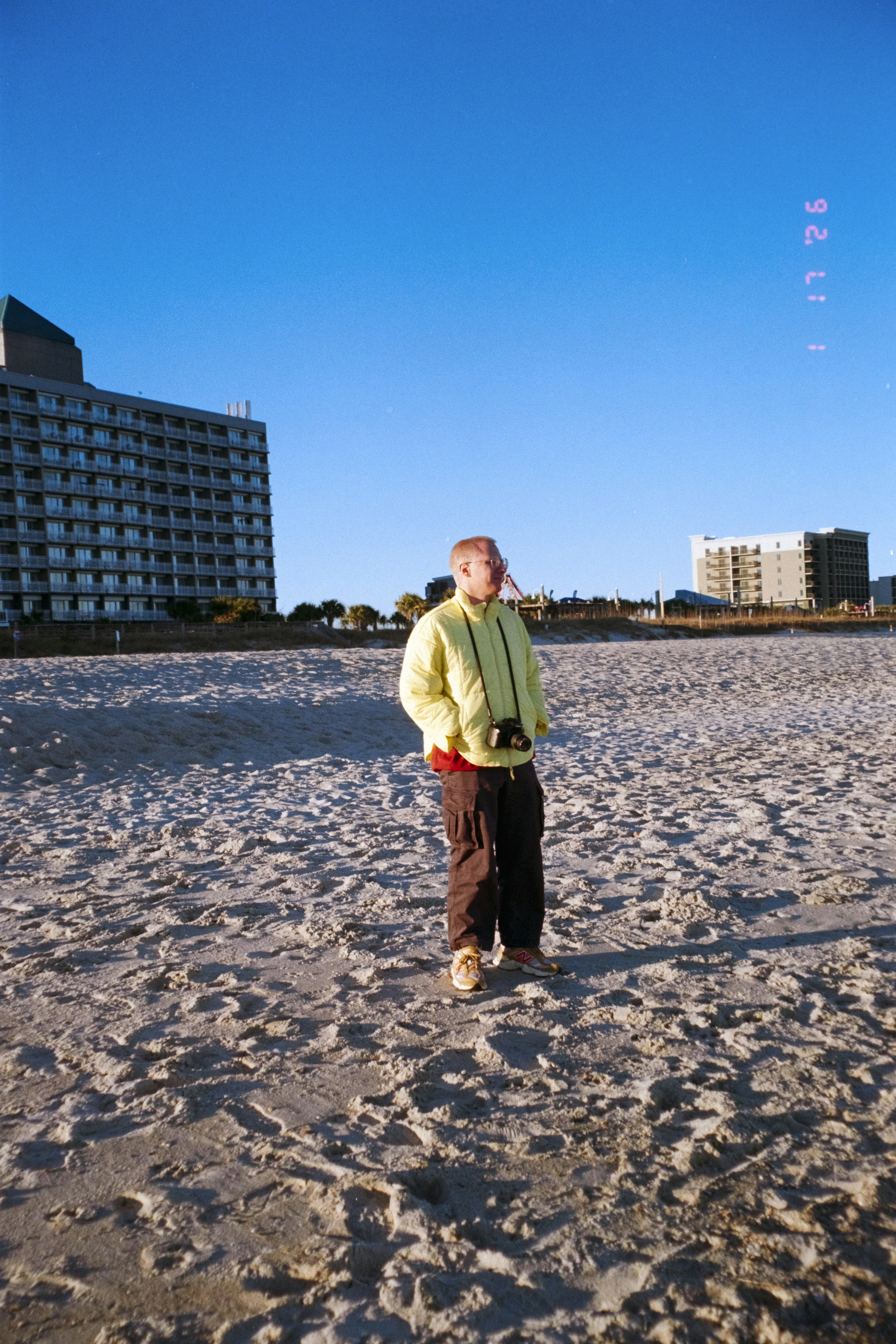 Lone Photographer on the Sand: A Coastal City Portrait at Golden Hour