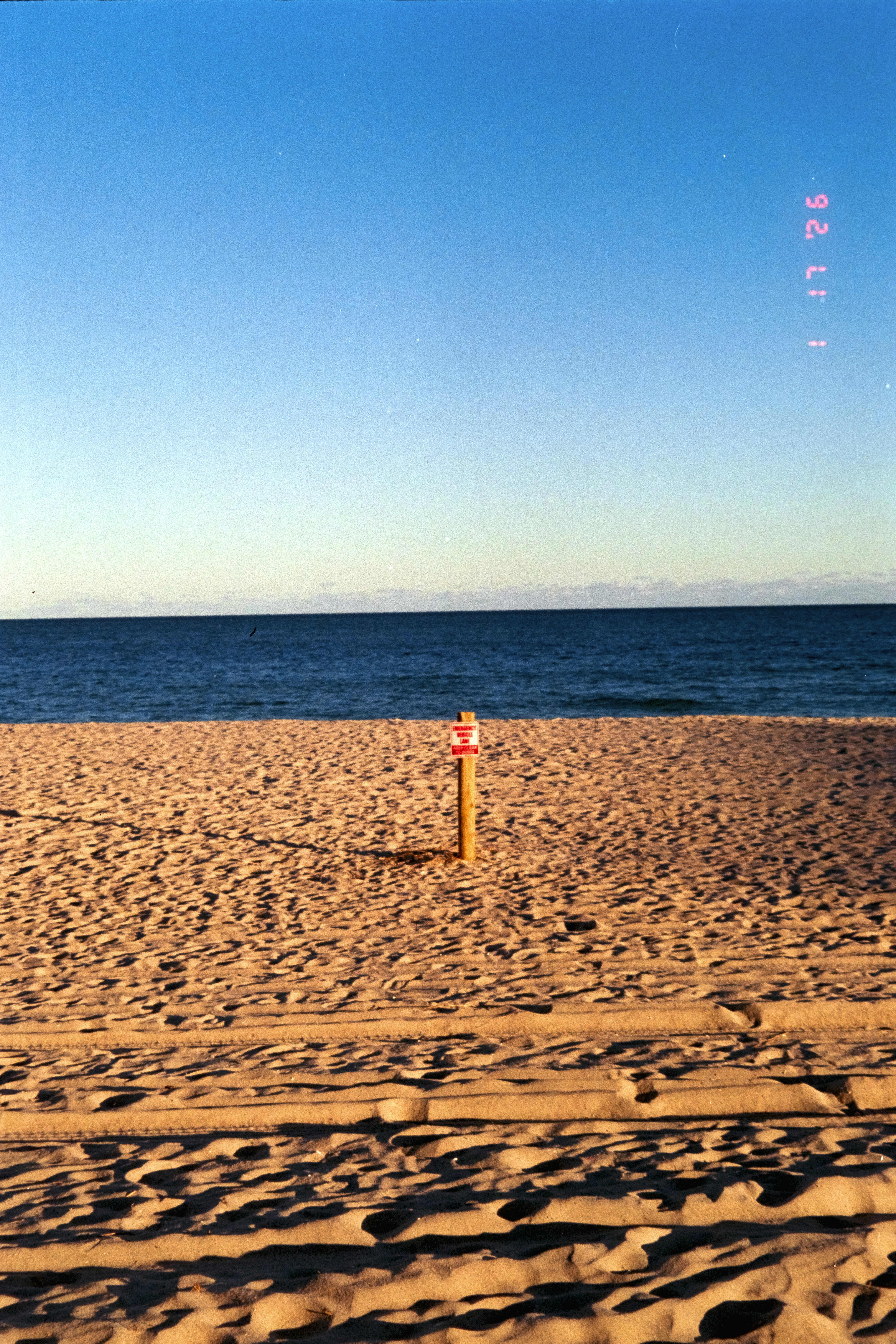 Lonely signpost on a quiet sunlit shoreline