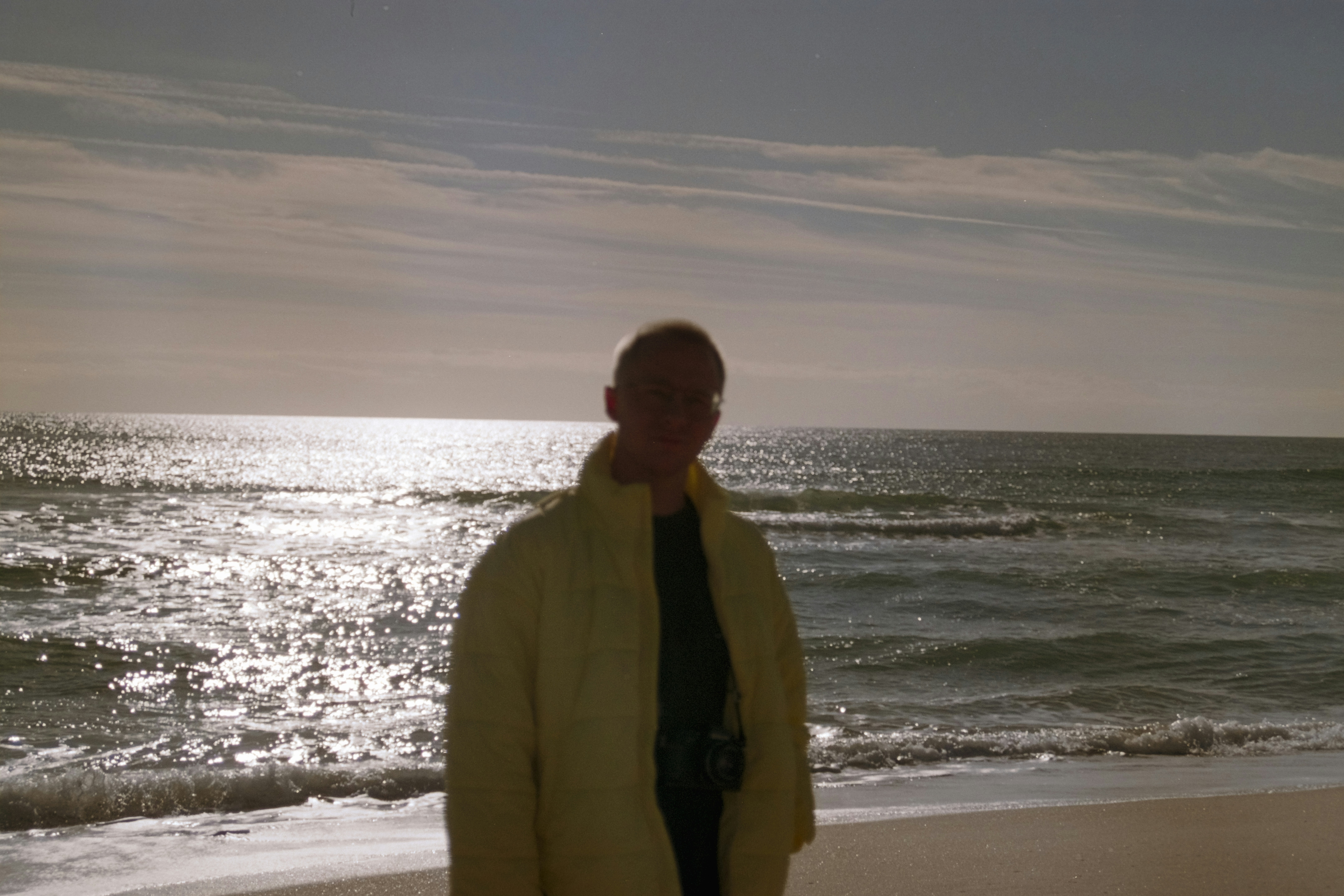 Backlit Beach Portrait with Silhouetted Figure in Soft Evening Light