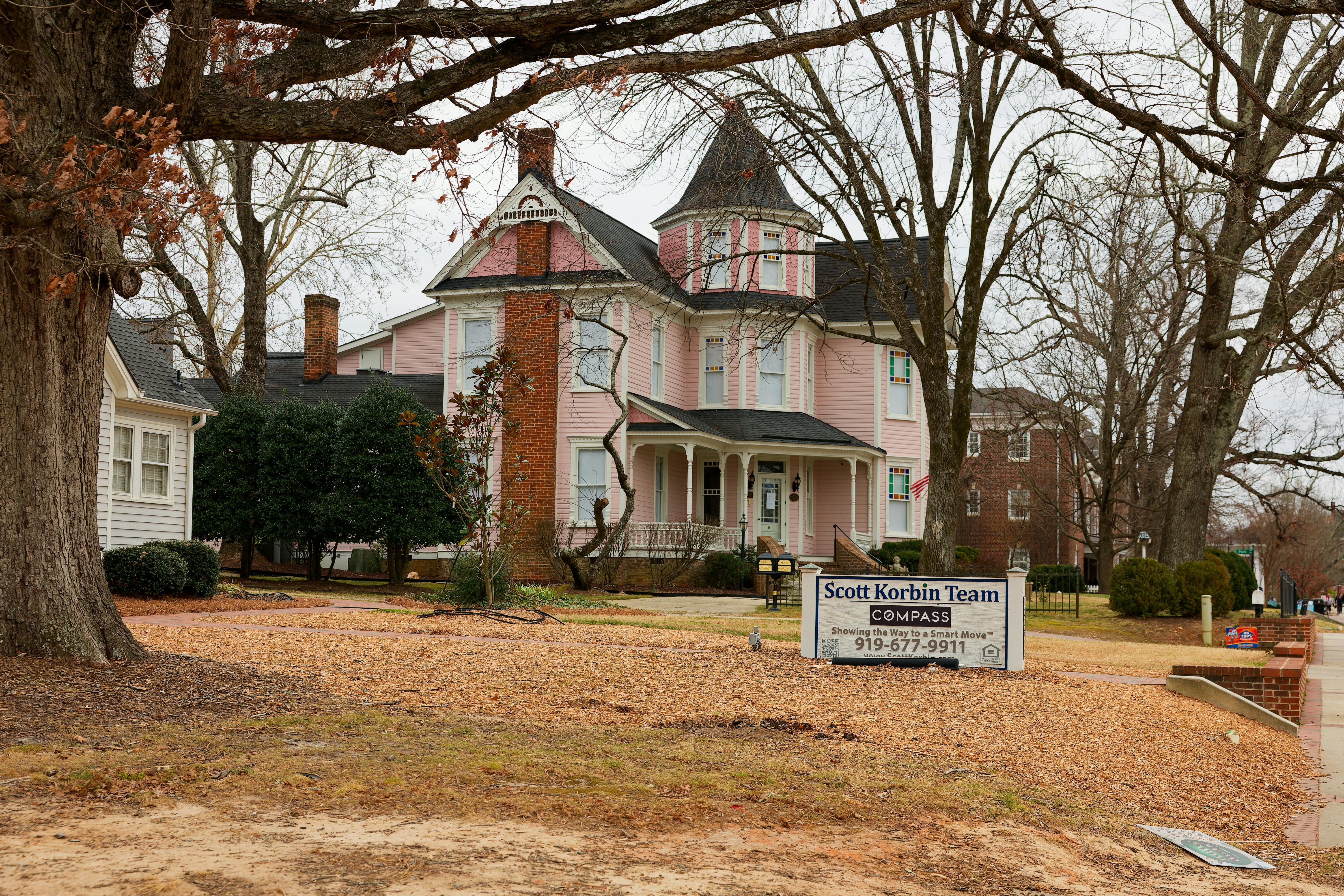 Pink Victorian Dream House with Real Estate Sign in Autumn Park