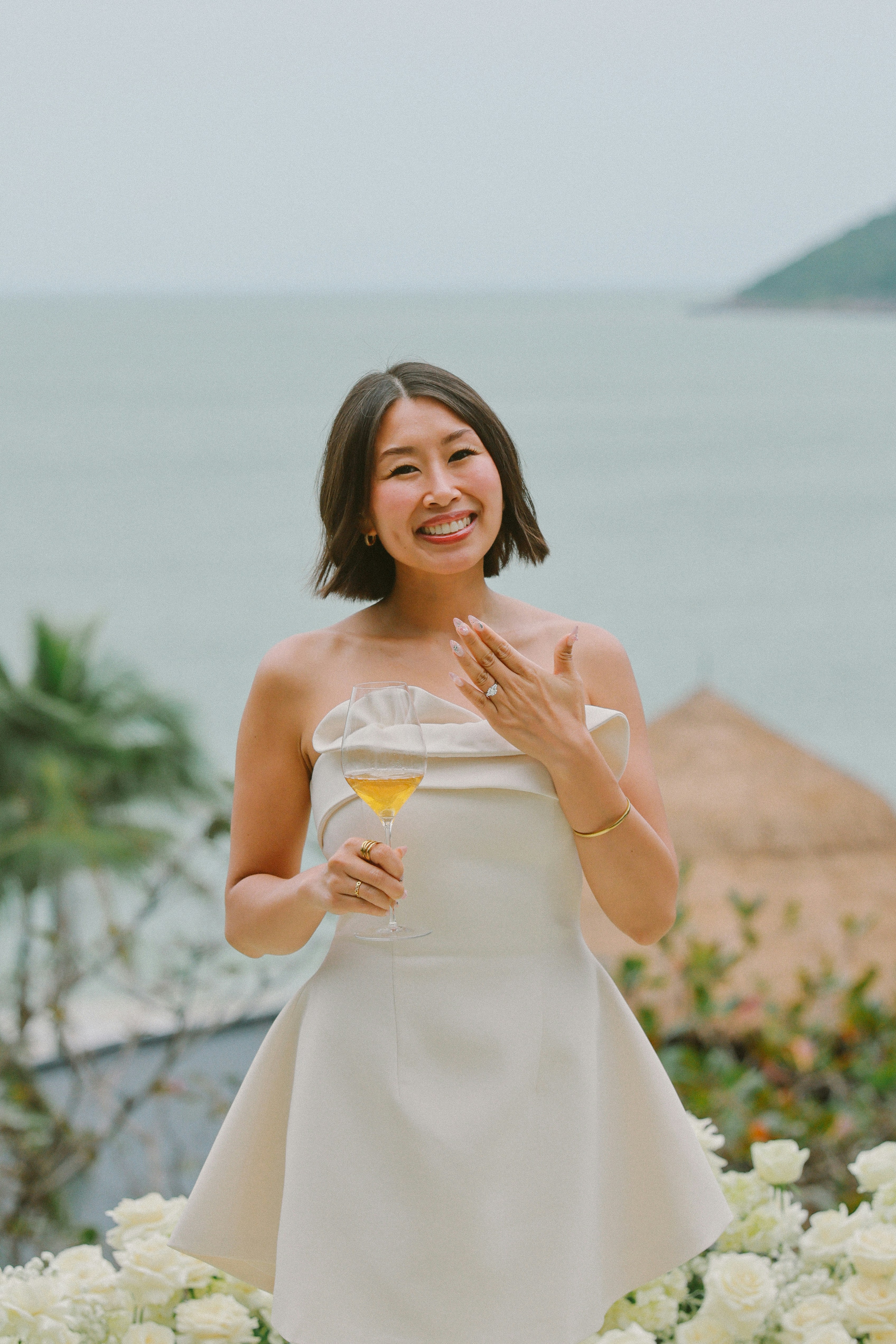 Joyful Bride by the Sea: A White Dress and Golden Toast