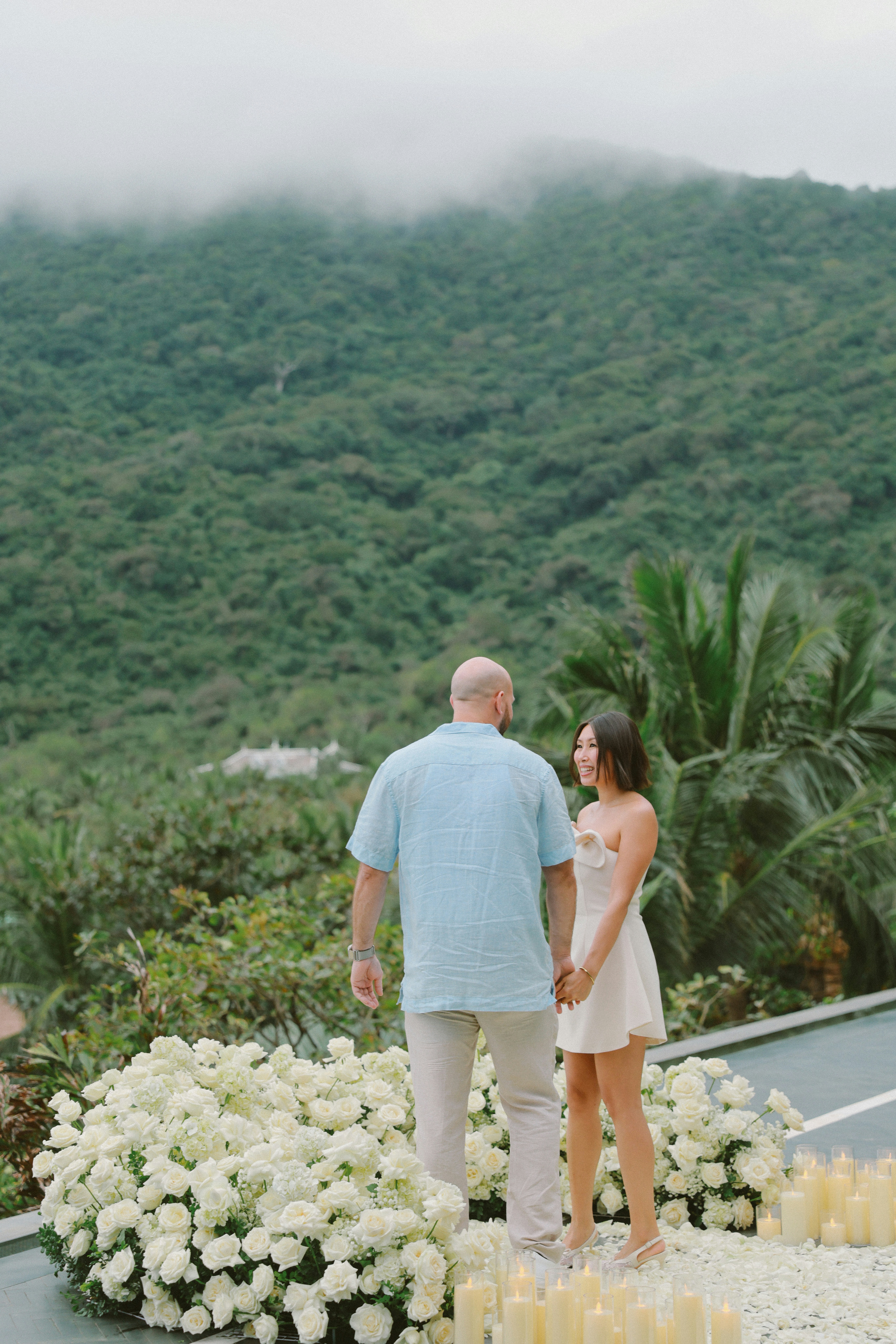 Sunlit vows at a cliffside ceremony among white blooms
