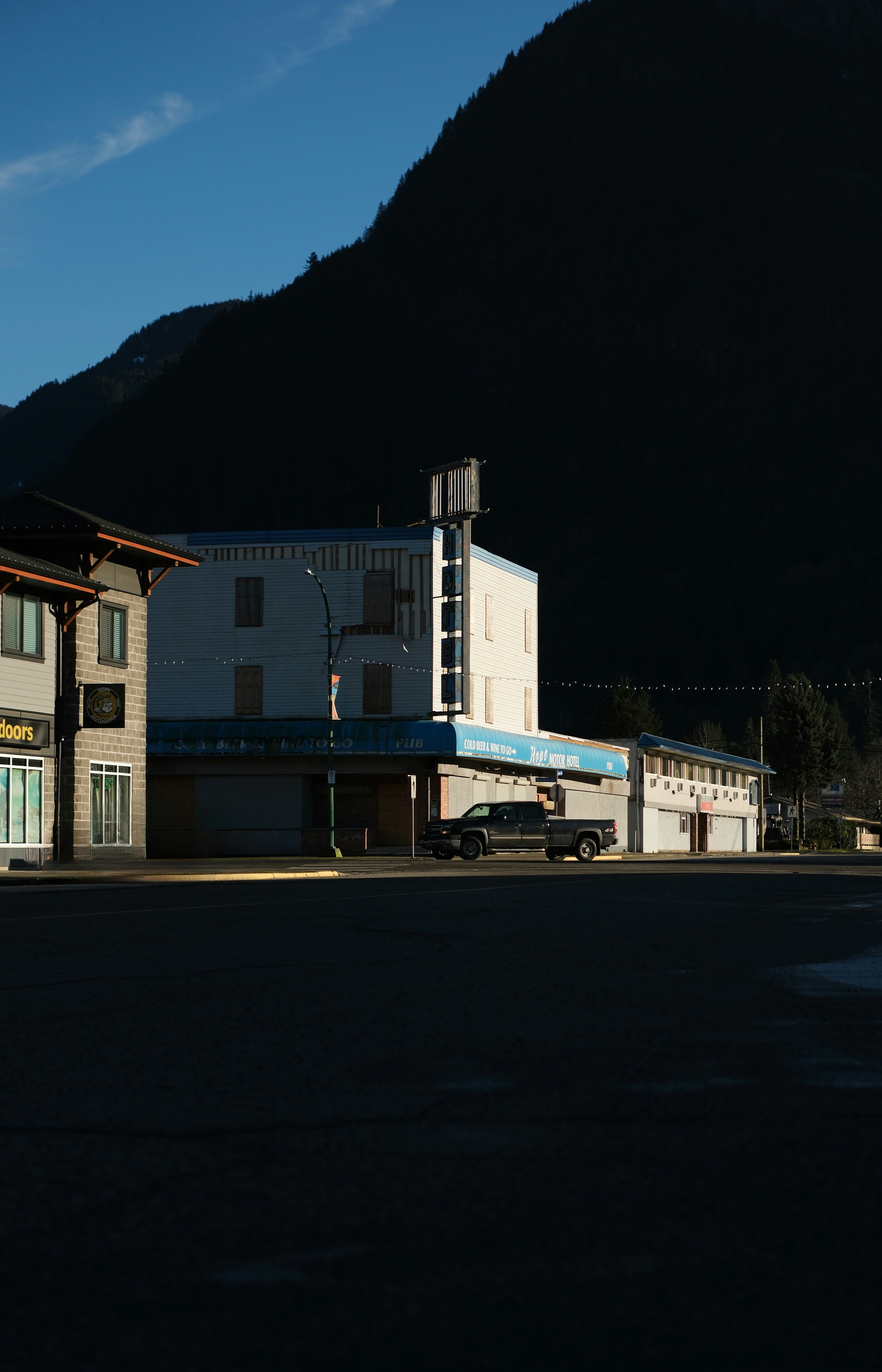 Sunlit Main Street Beneath a Shadowed Mountain