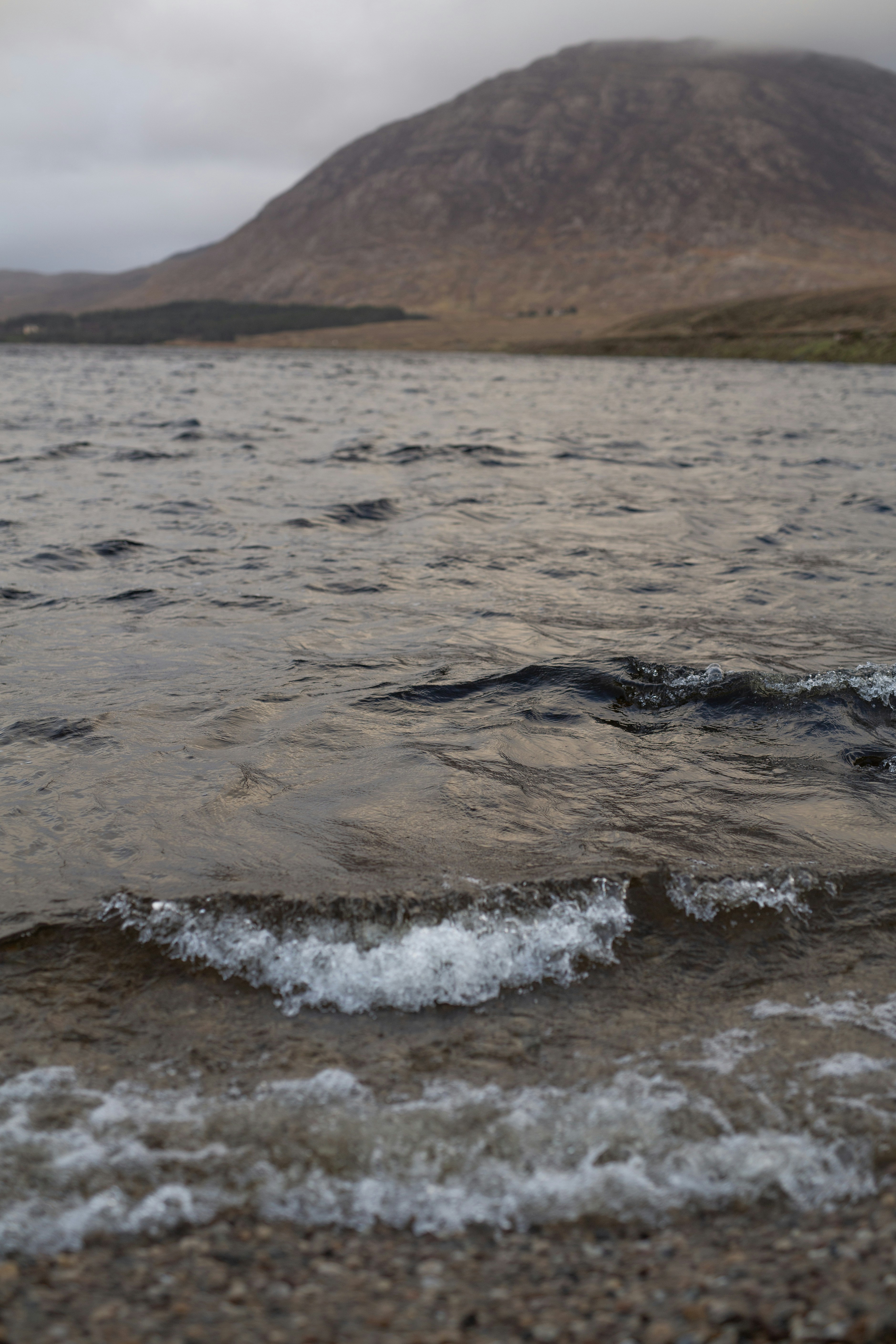 Rippled Shoreline Beneath a Distant Hill