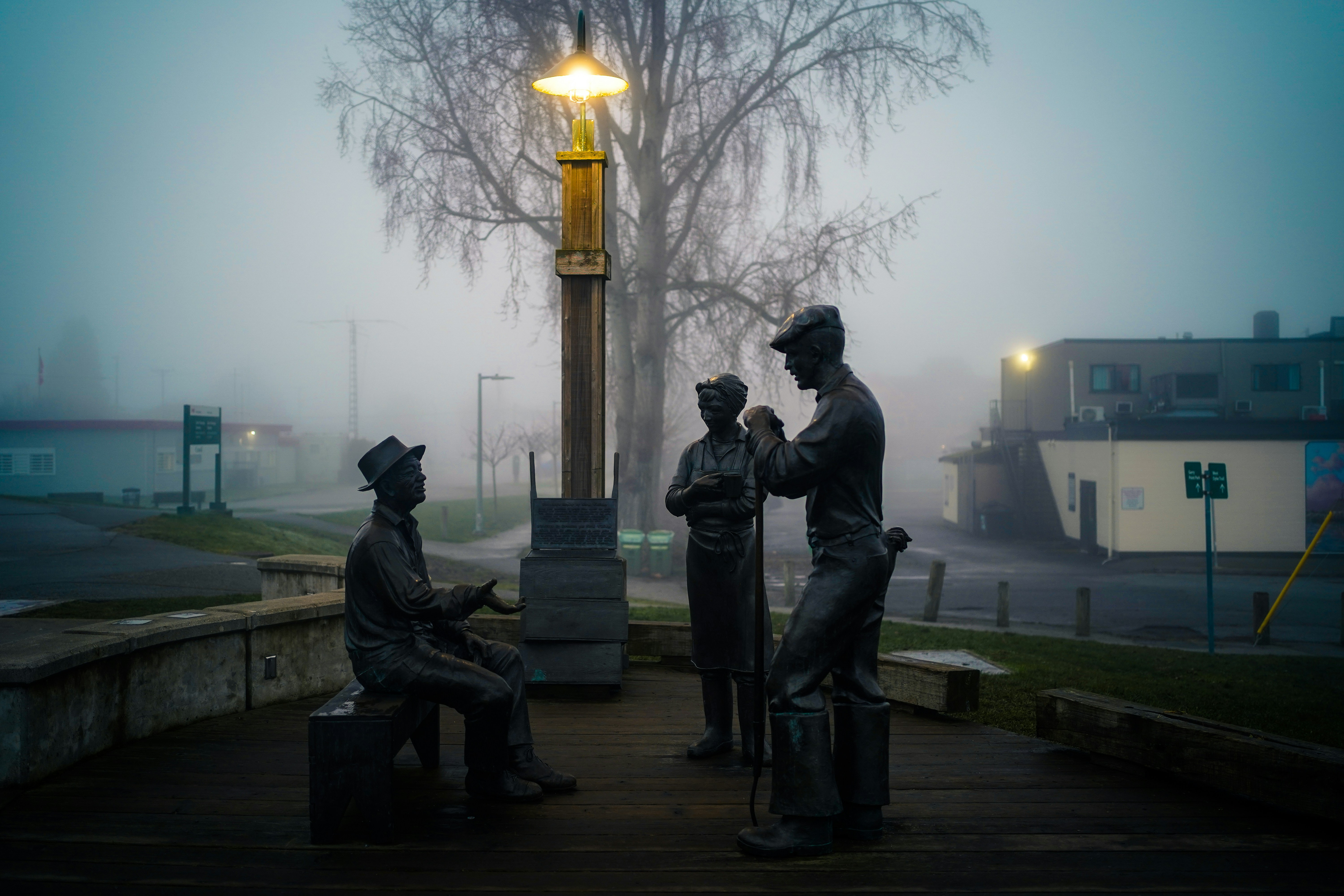 Silent Echoes: Bronze Figures on a Misty Pier