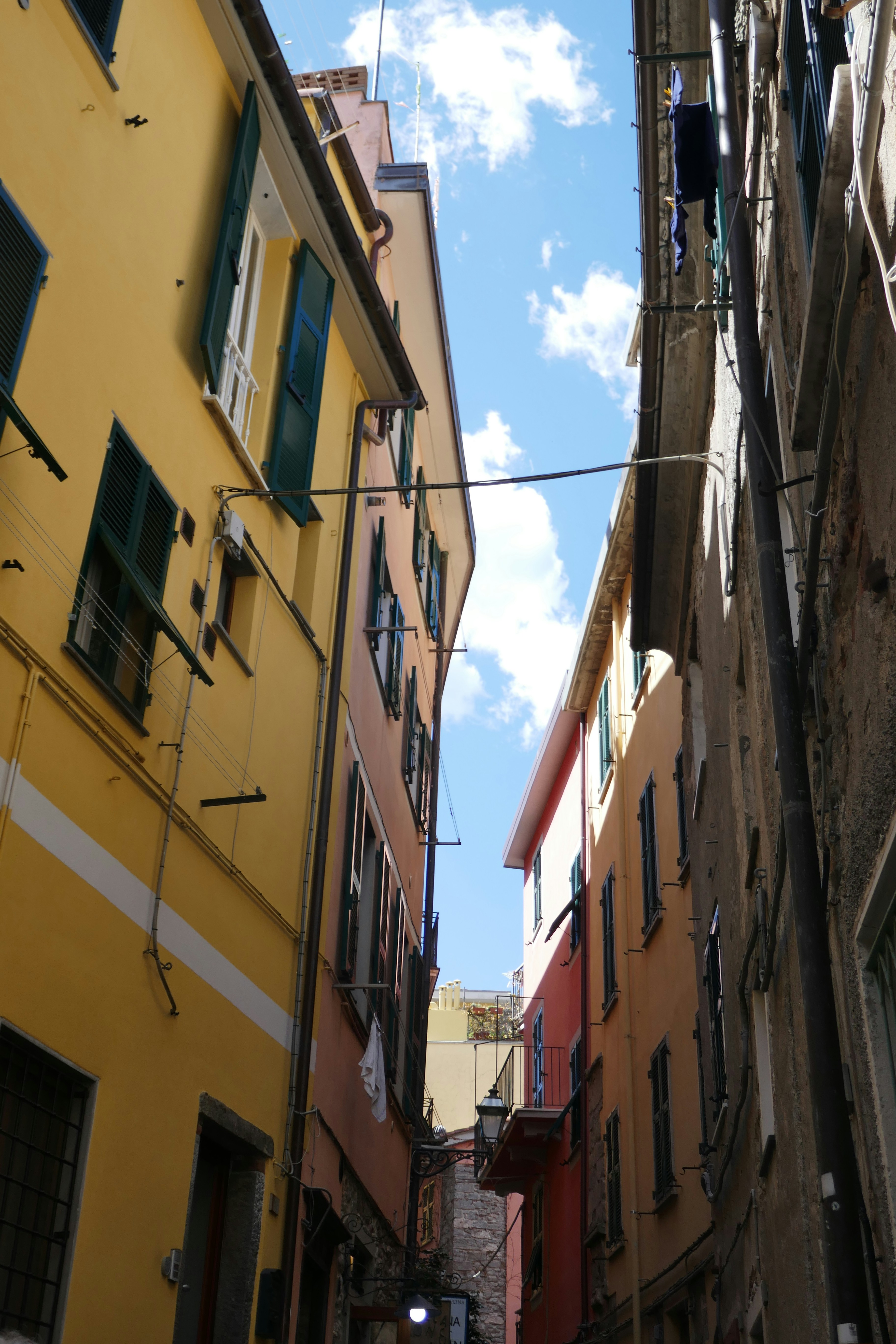 Skyward Alley: Sunlit Facades Between Colorful Walls
