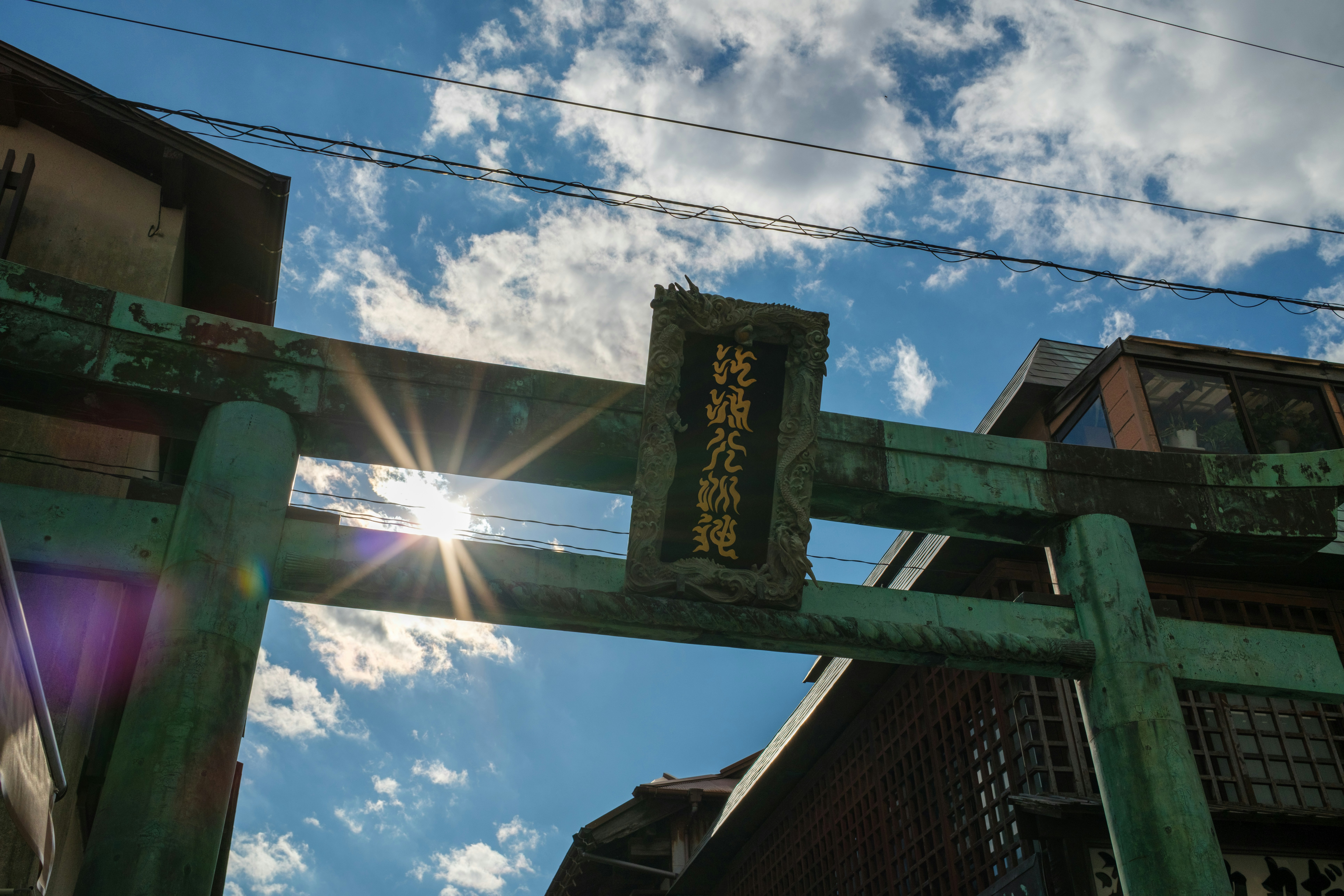 Sunburst Through a Green Torii Gate under a Blue Sky