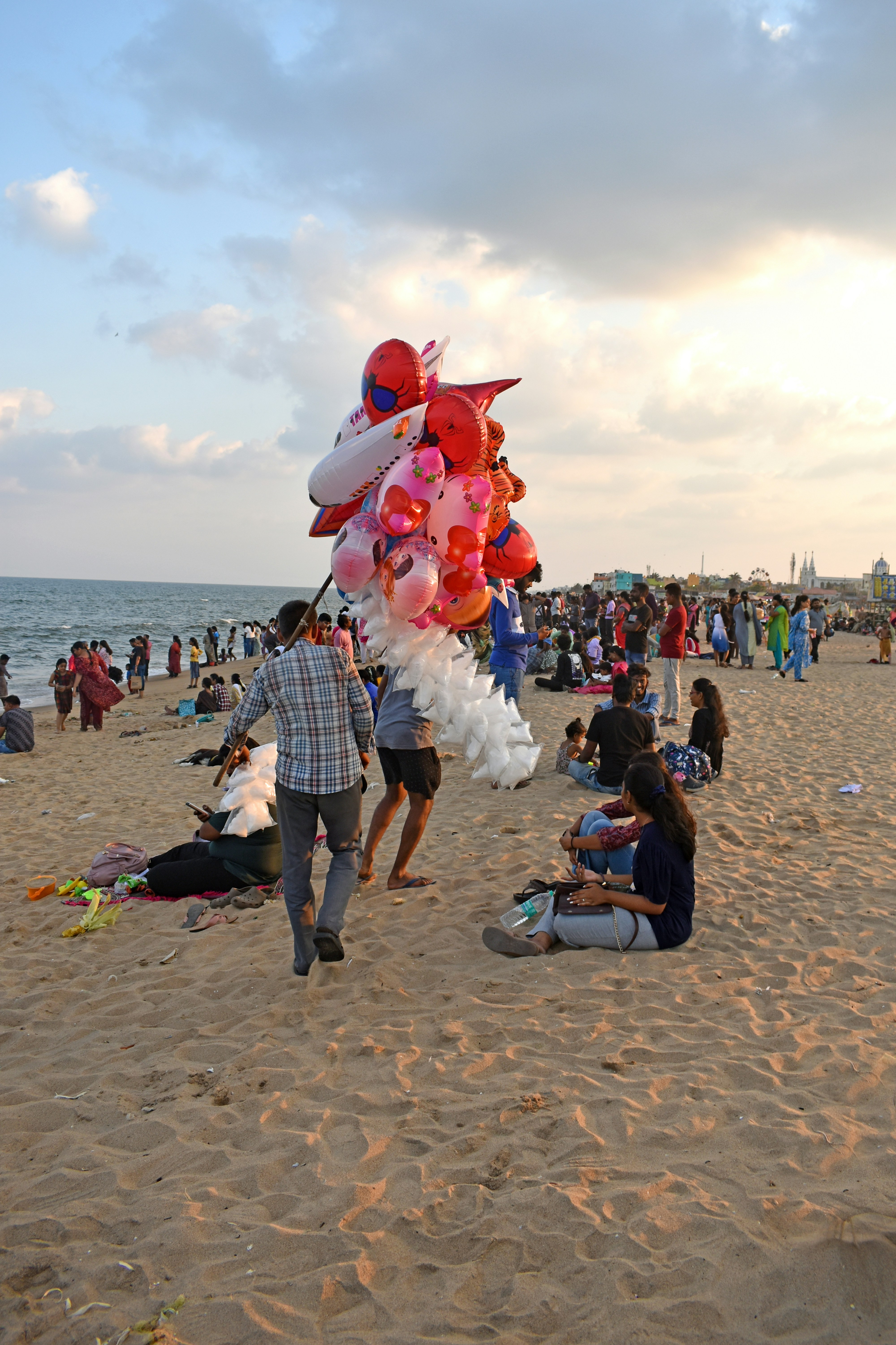 Colorful Balloon Vendor at Sunlit Beach crowds