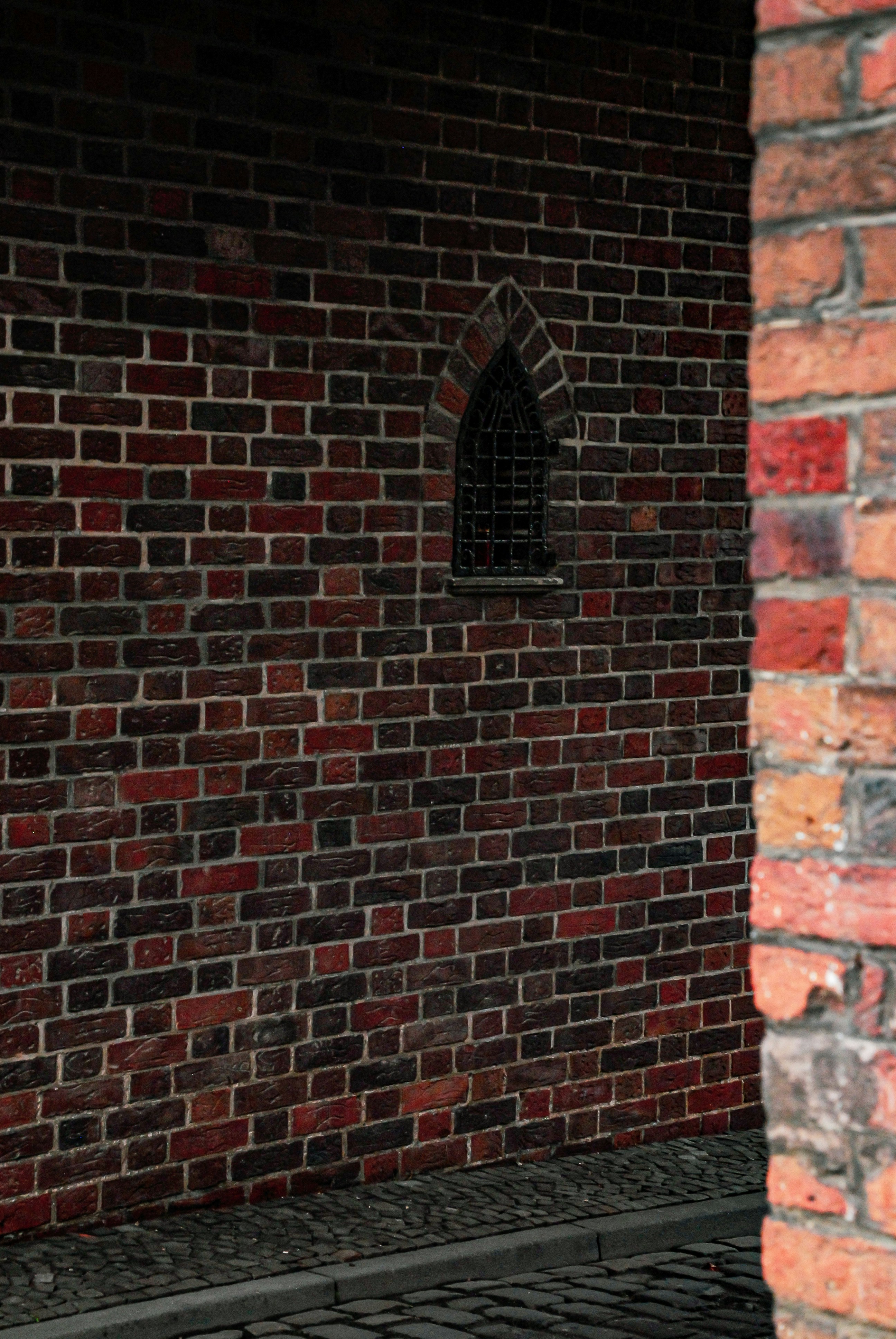 Brickwork Veil: A Narrow Window in Red and Shadow