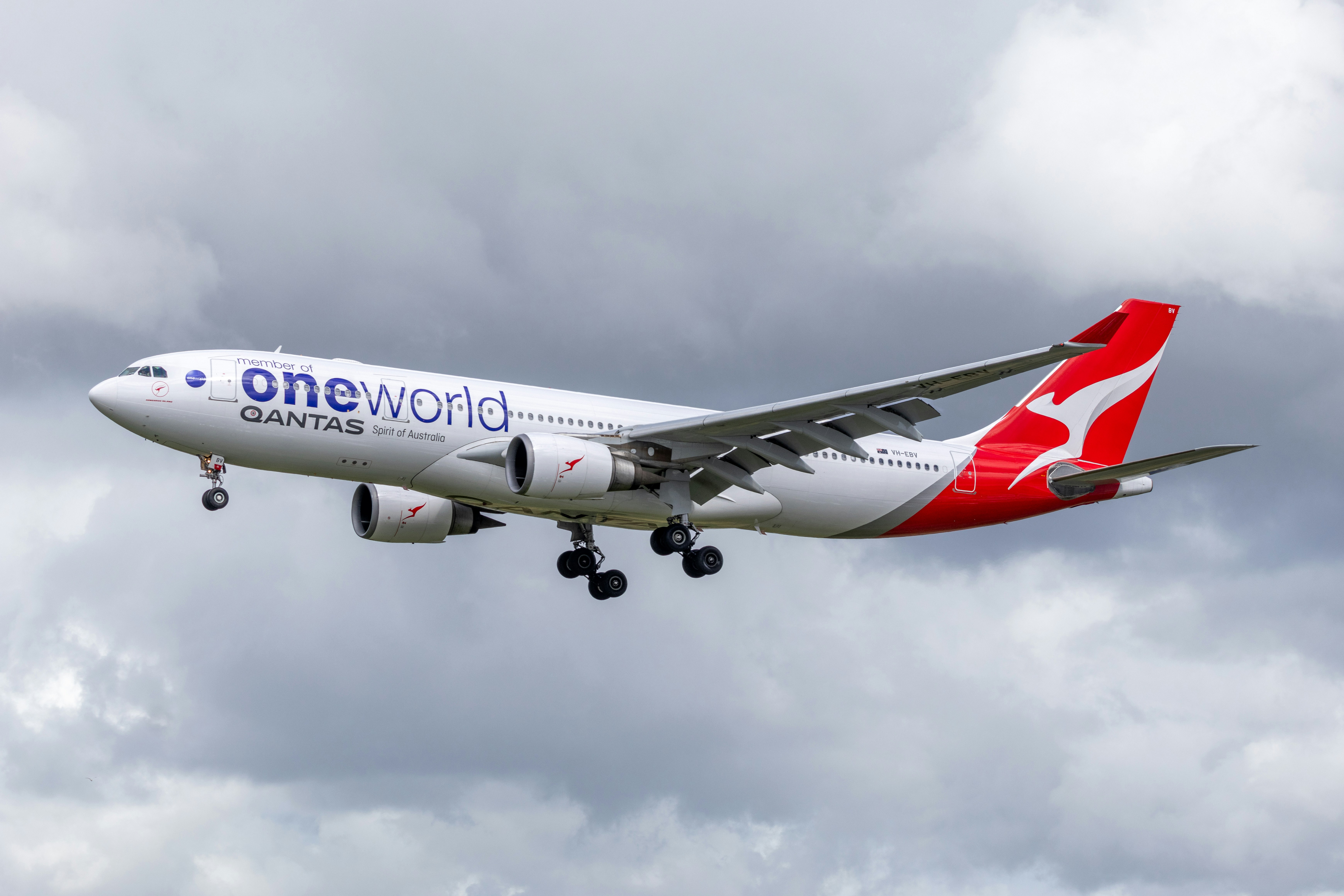 Qantas OneWorld in Transit: A Crane-Like Landing Under Clouded Sky