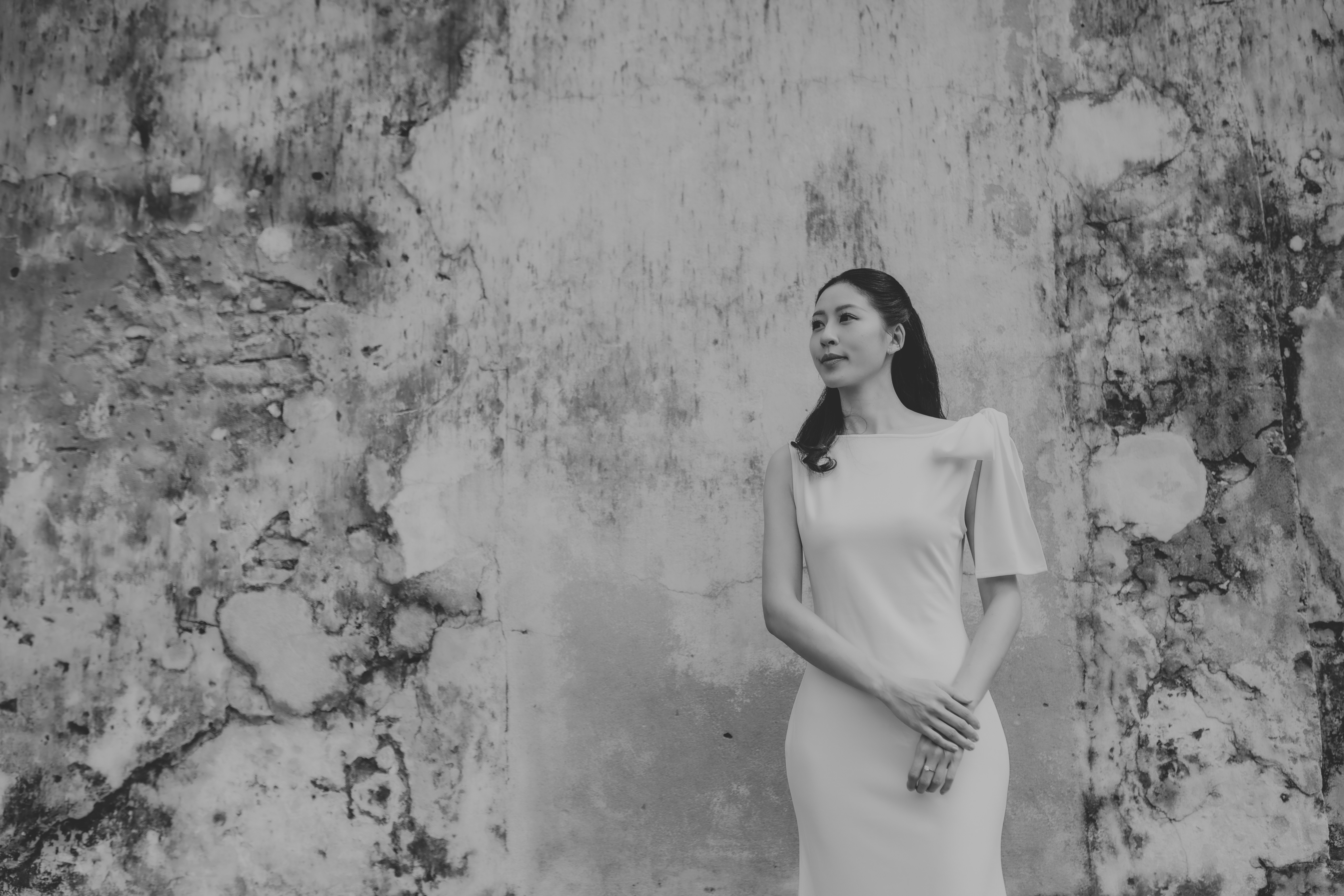 Graceful silhouette: a poised figure against a textured wall