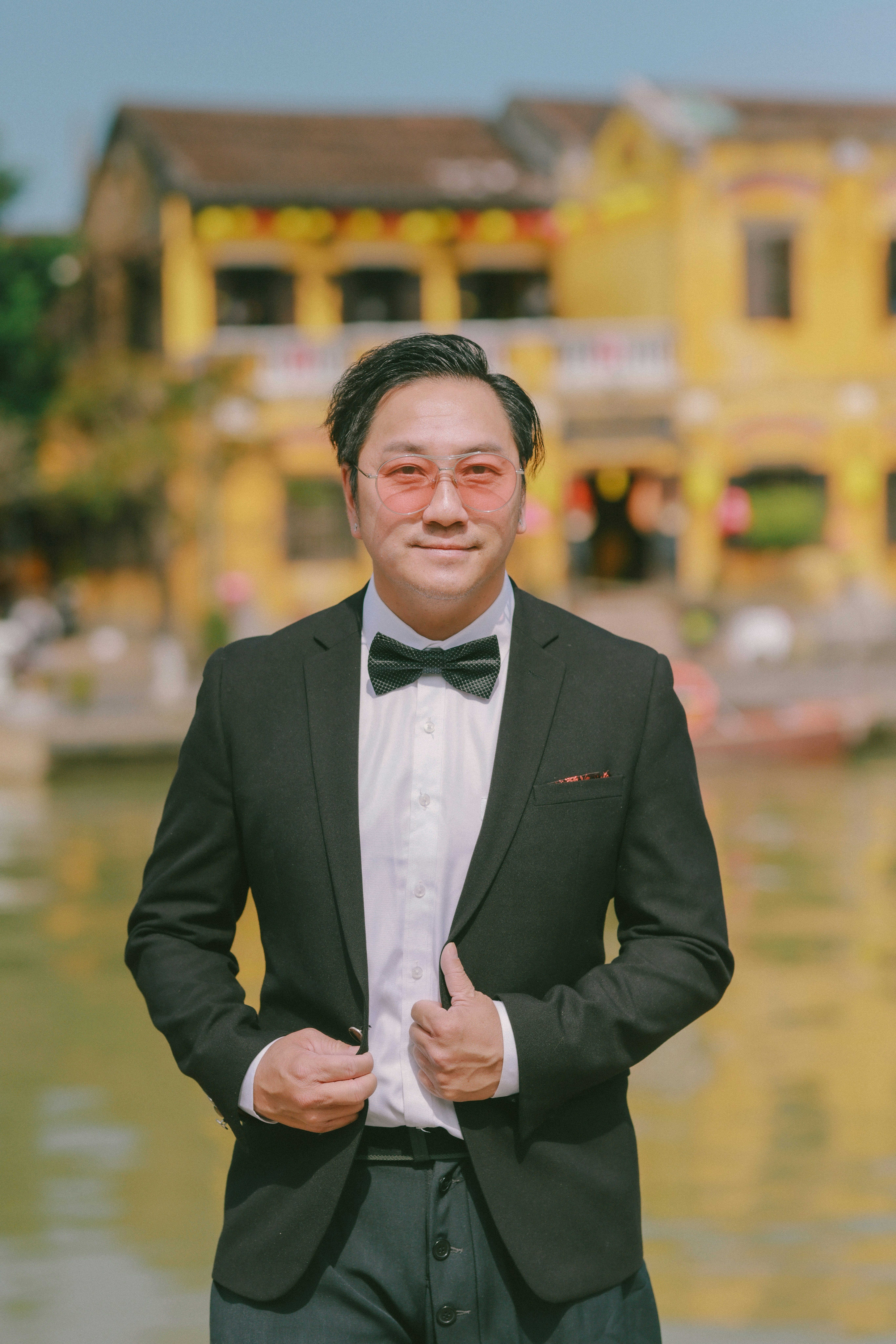 Gentleman in Black Tie at a Sunlit Courtyard