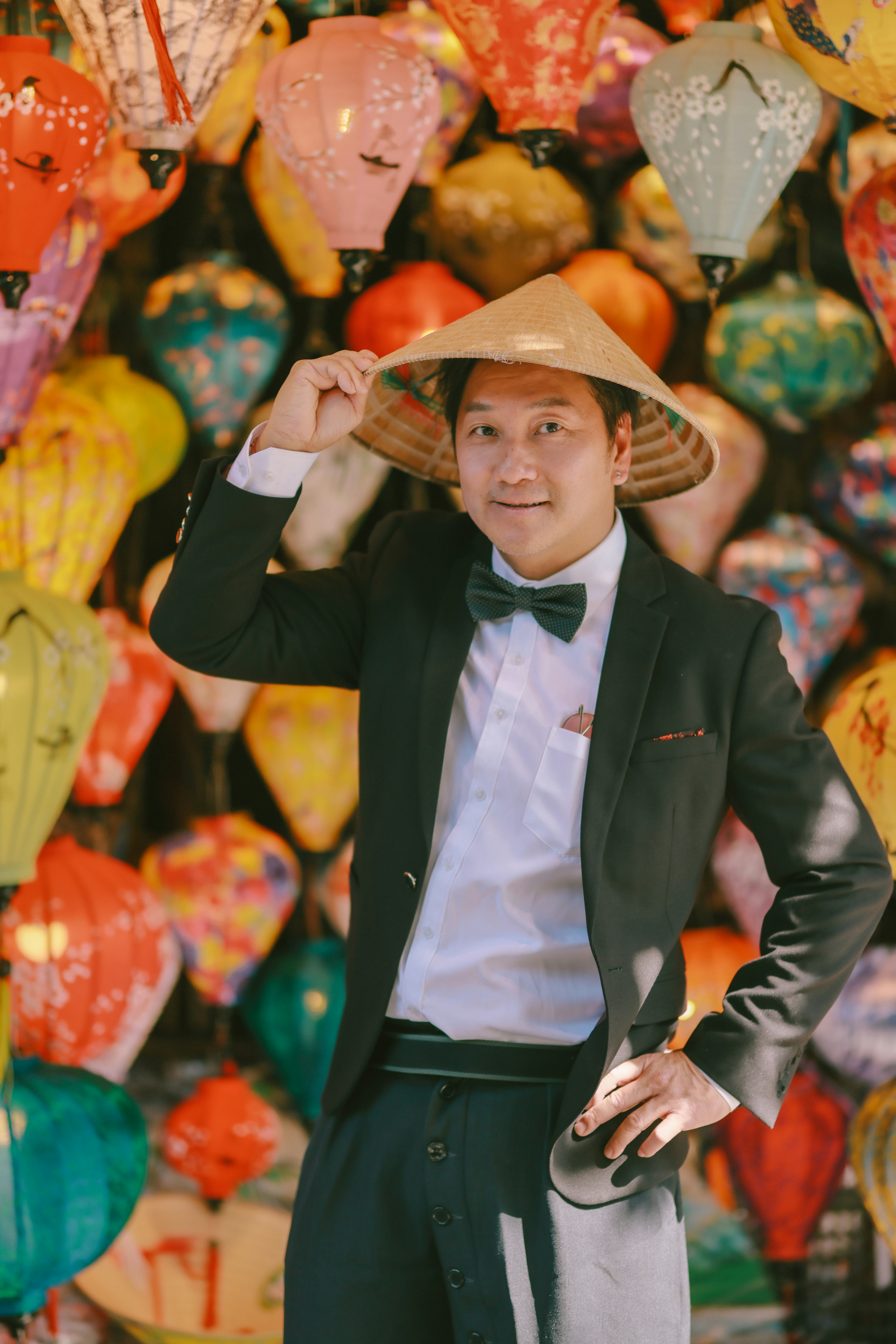 Portrait in a Burst of Lanterns: A Dapper Moment Amid Colorful Orbs