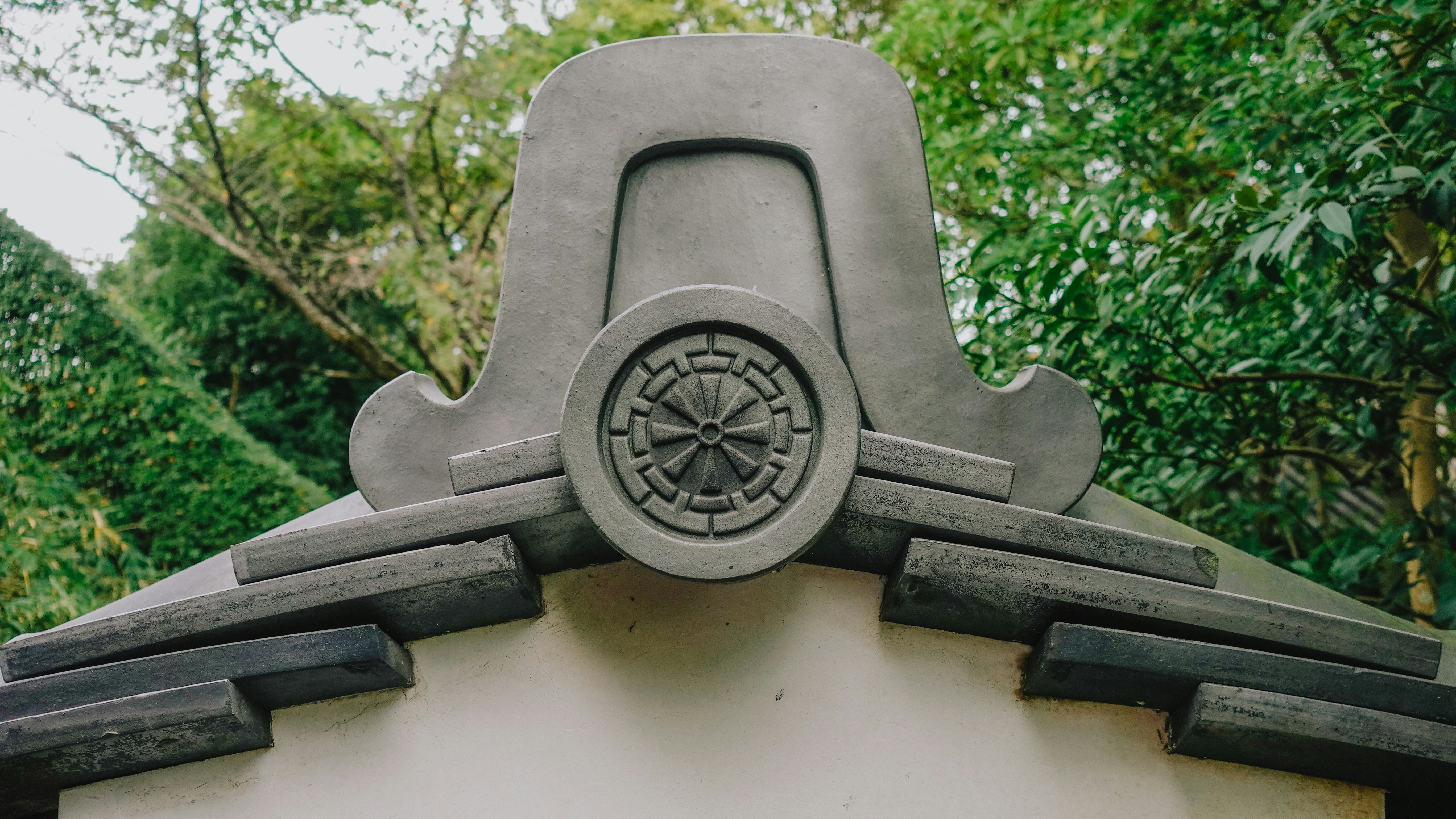 Glyph on the Roof Crest: A Silent Ornament Amid Lush Green