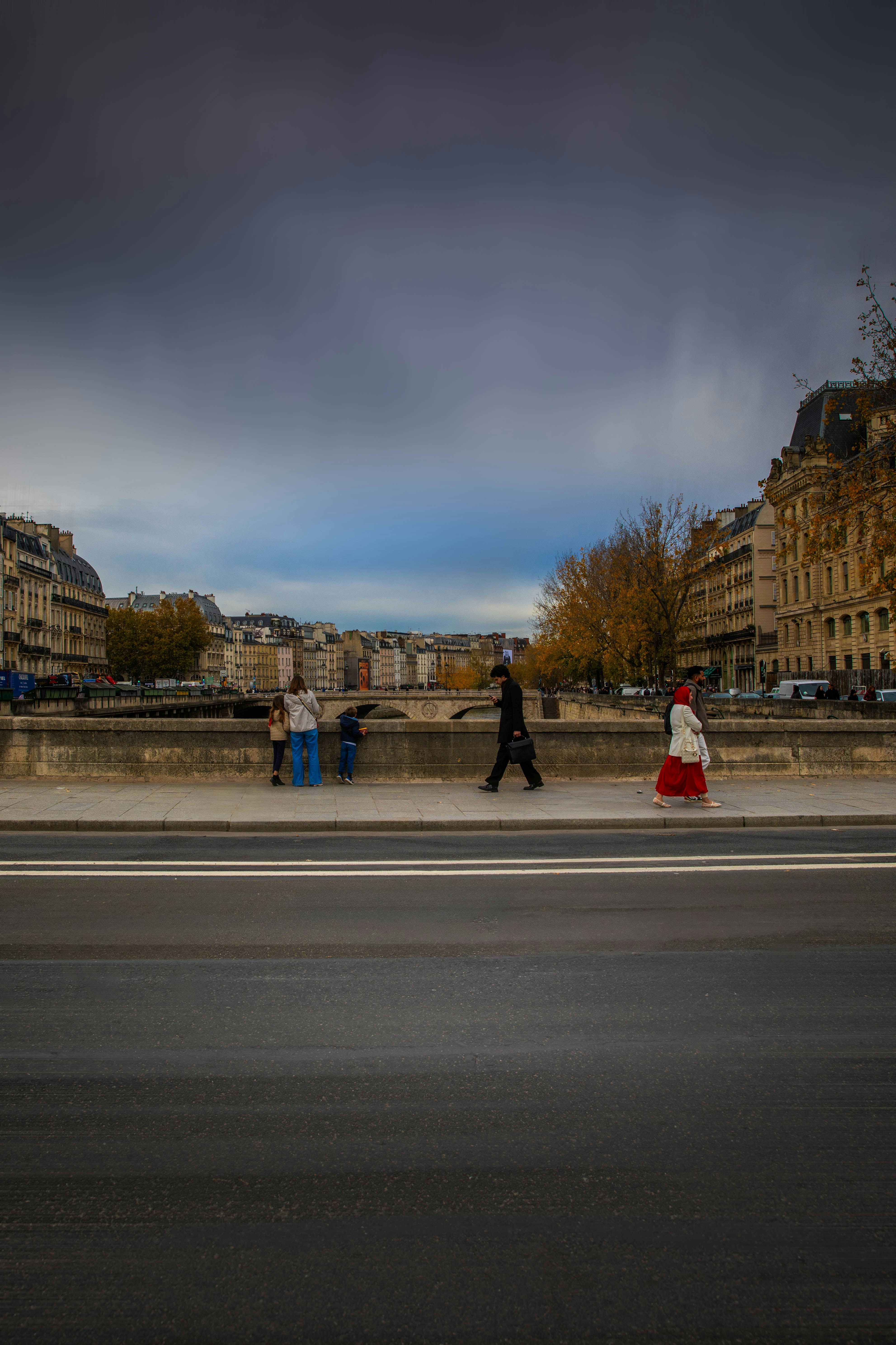 Riverbank Parade: A City Walk Beneath a Vast Sky