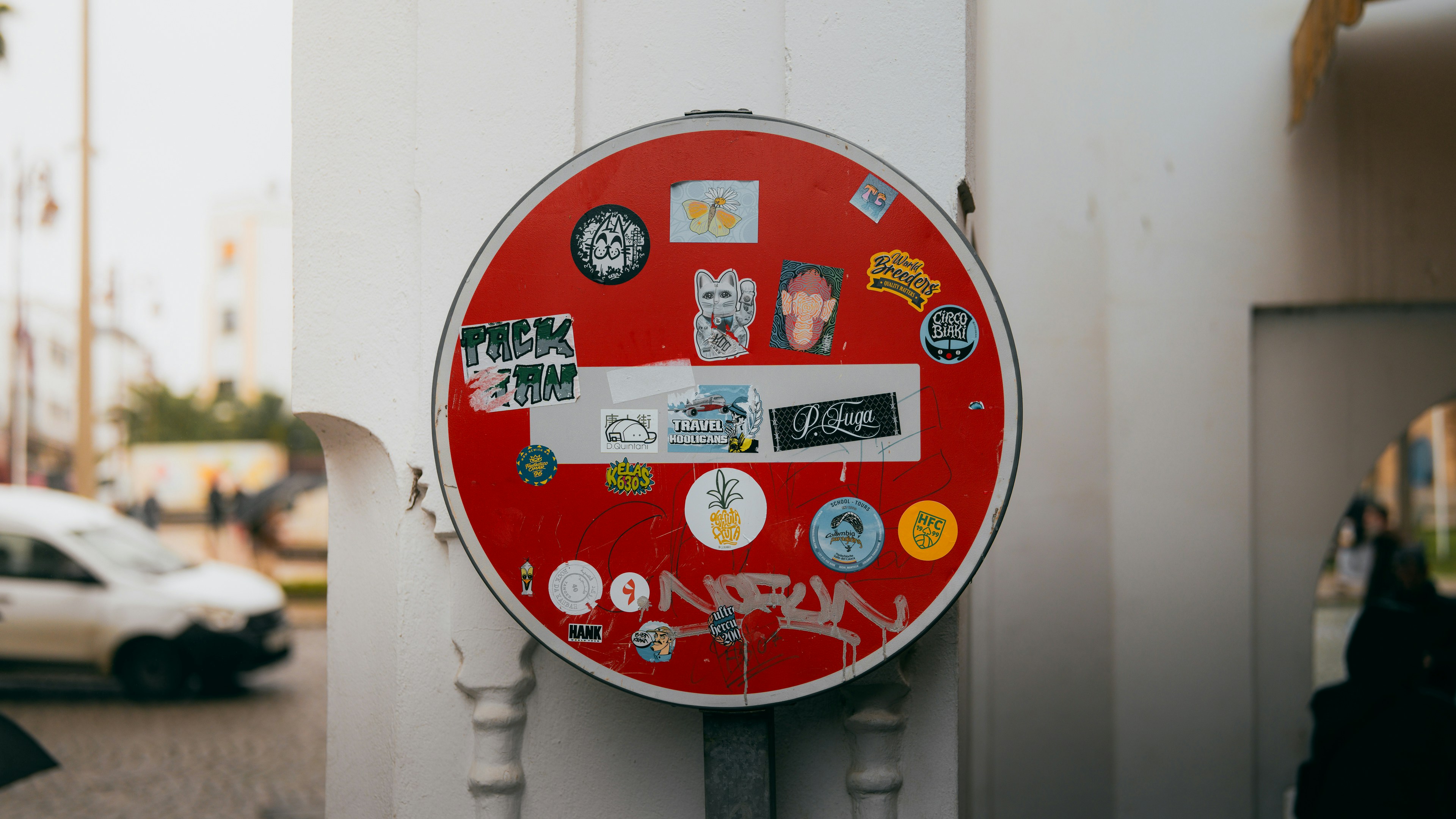 Stickered Red Circle: Urban Collage on a Pillar