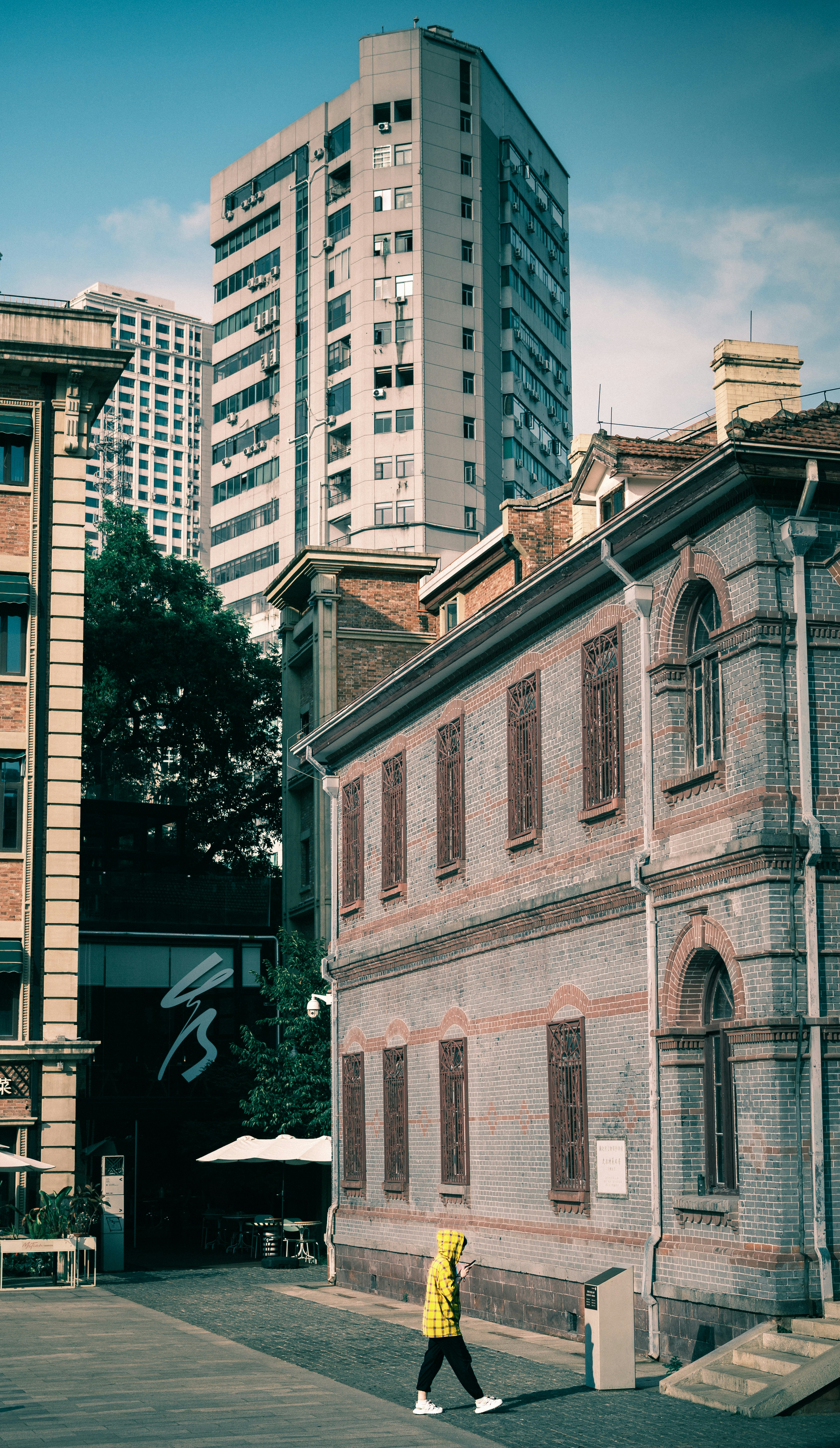 A Quiet Pedestrian Thread between Brick and Glass Skyscrapers