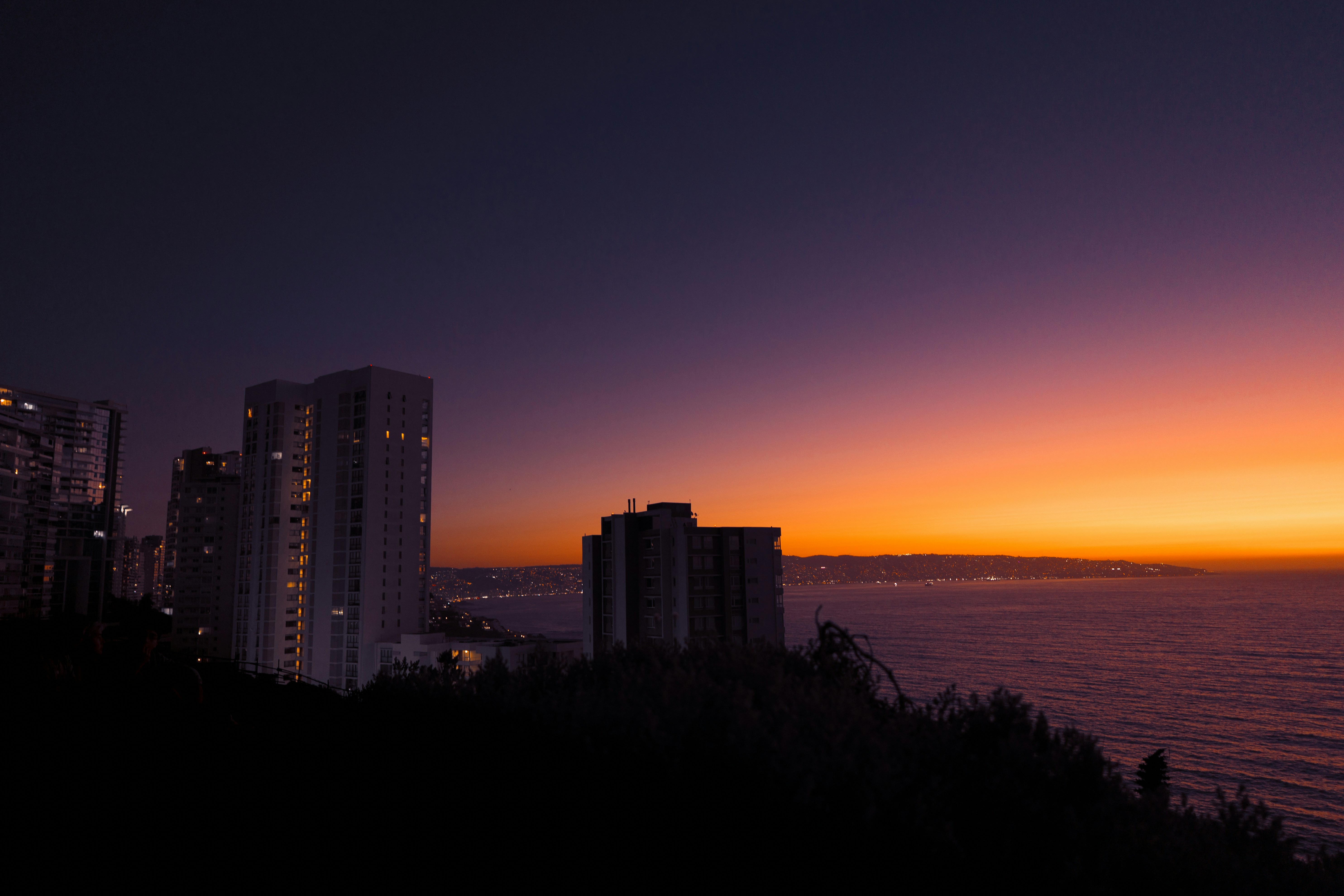 Twilight Coastline: City Shadows Meet a Dying Sun