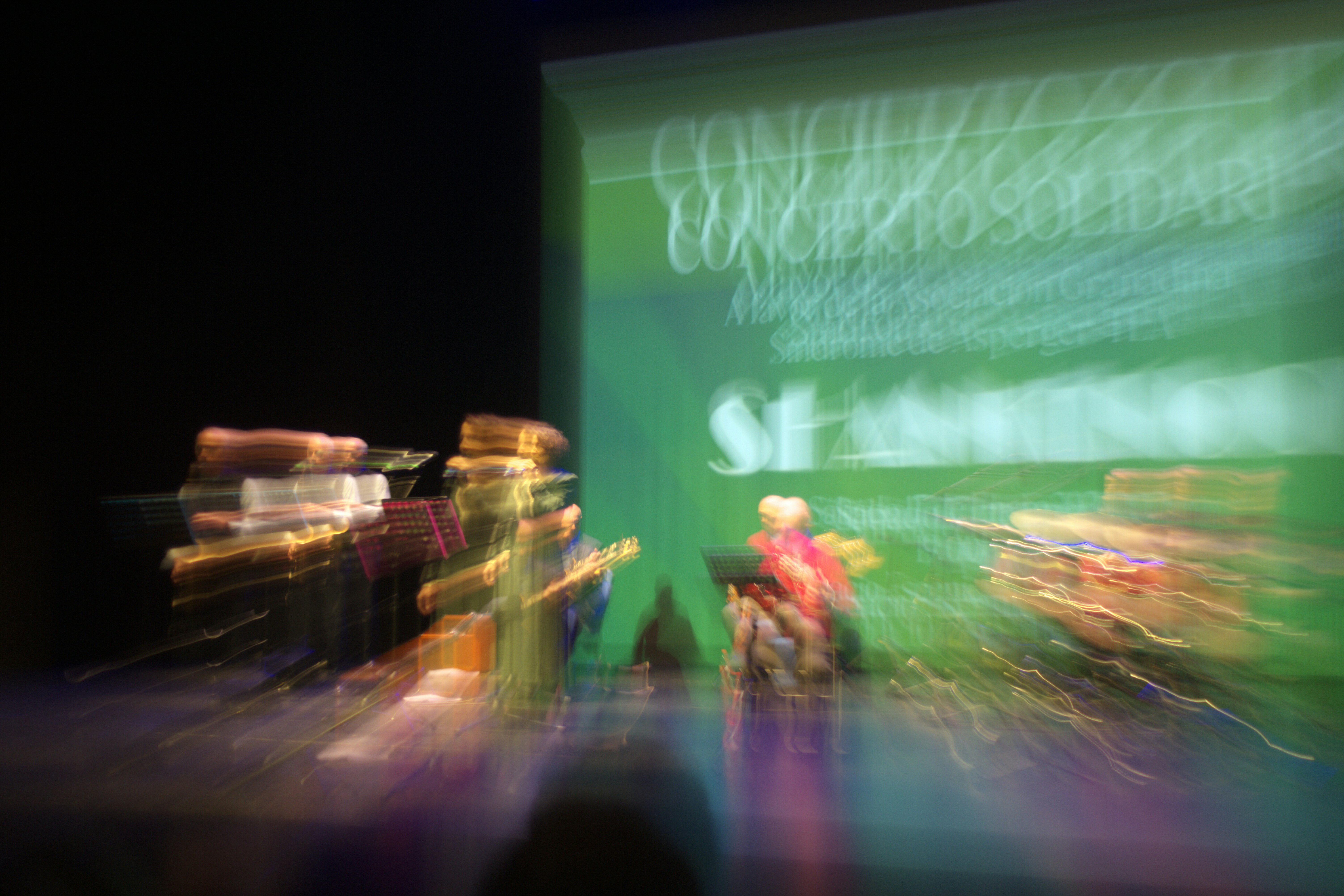 Blurring Spotlight: A Dim Stage with Moving Musicians under a Green Backdrop