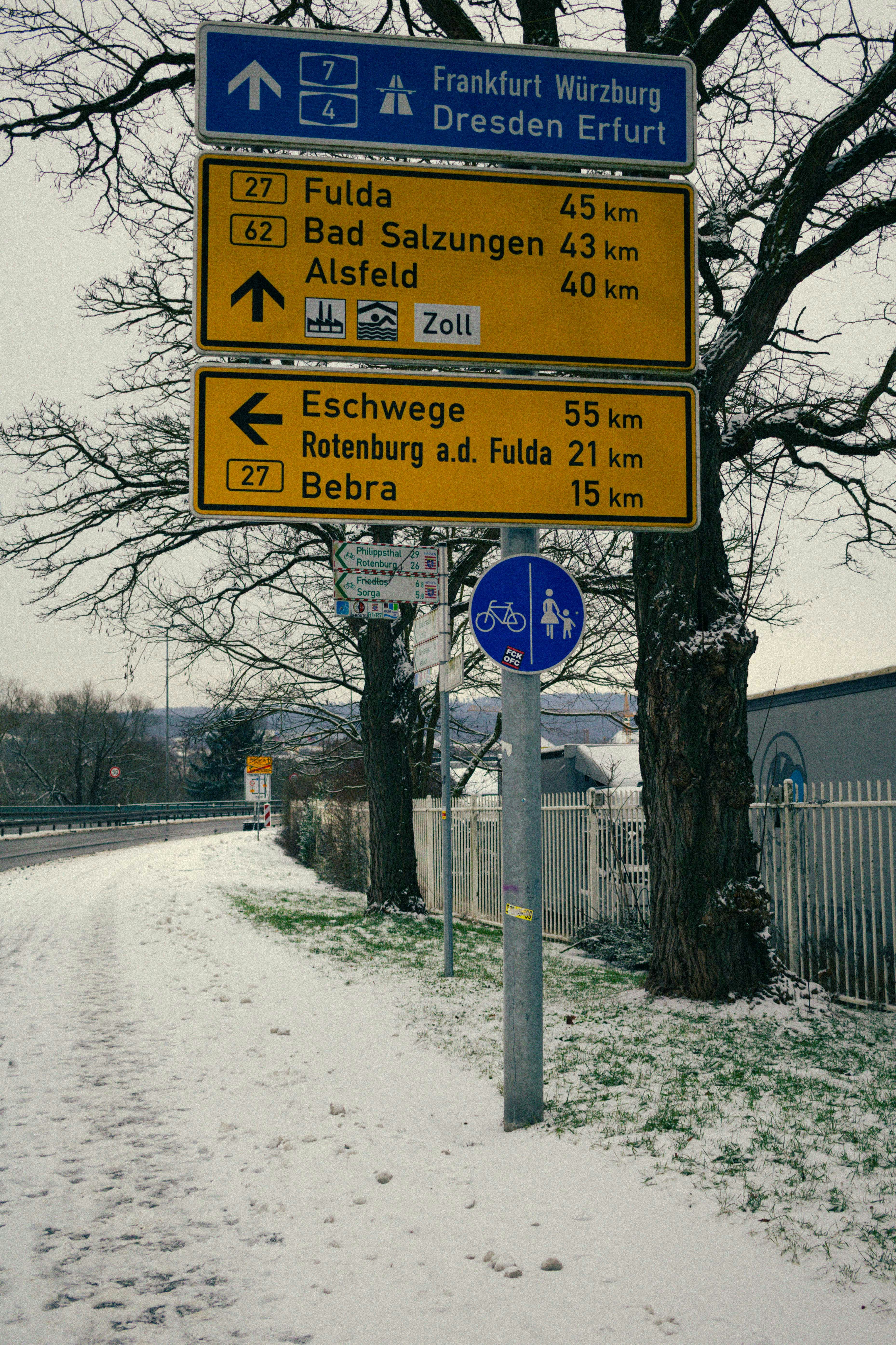 Yellow Street Signs in a Snowy German Street