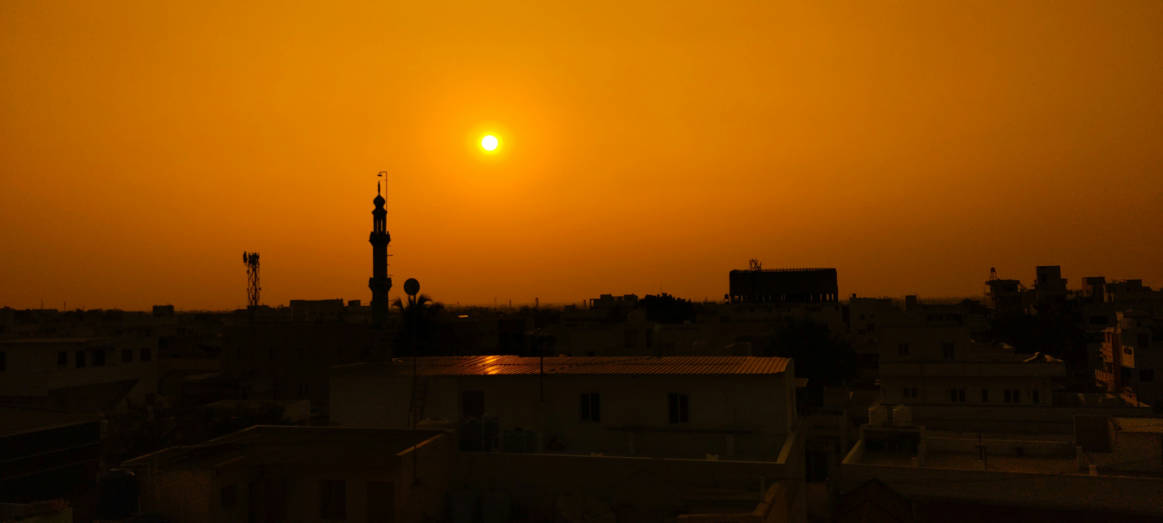 Golden Hour Over the City: Sunset Silhouette and Distant Skyline