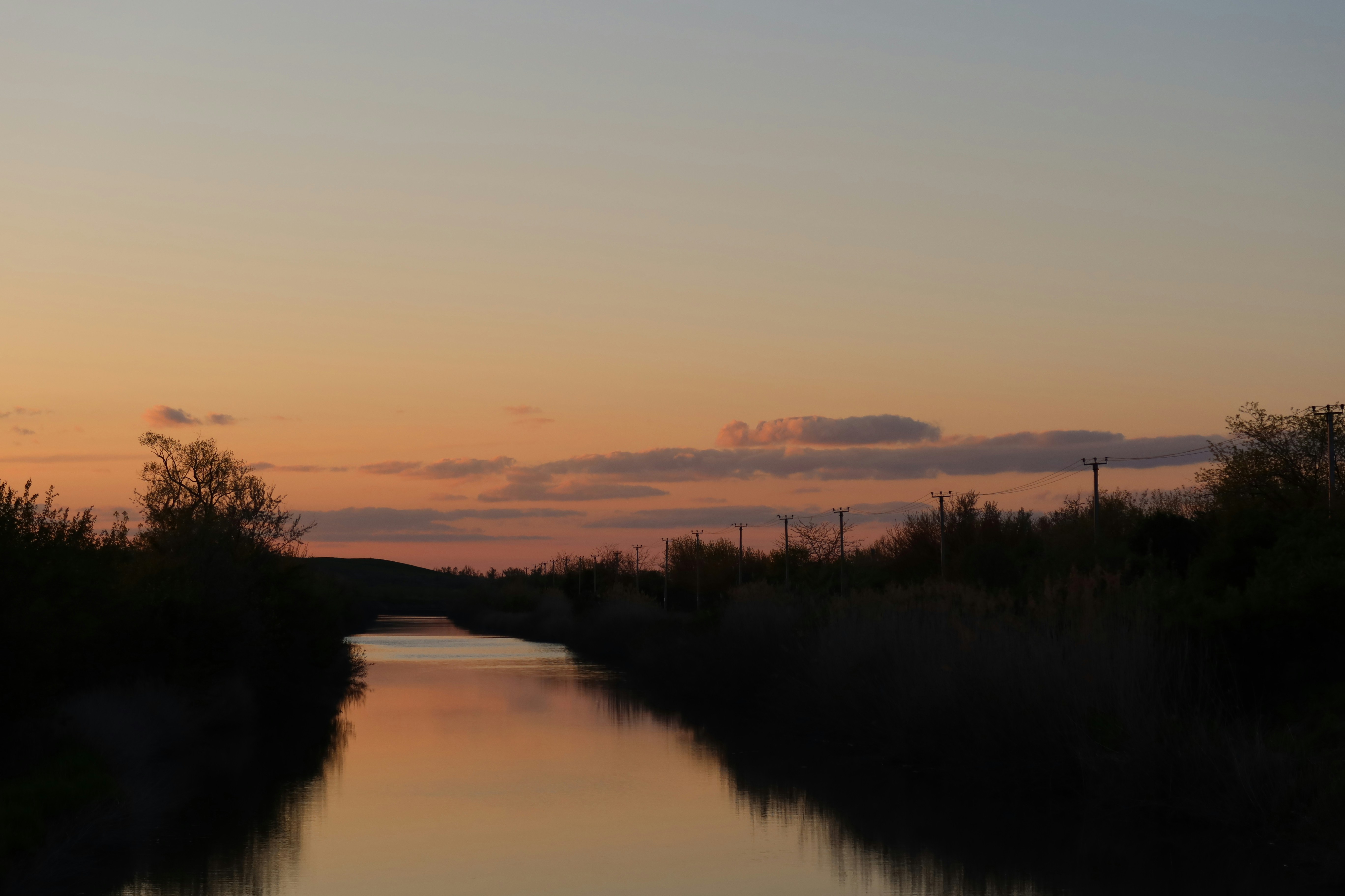 Dusk Along a Narrow Canal: Silhouettes at the Quiet Horizon